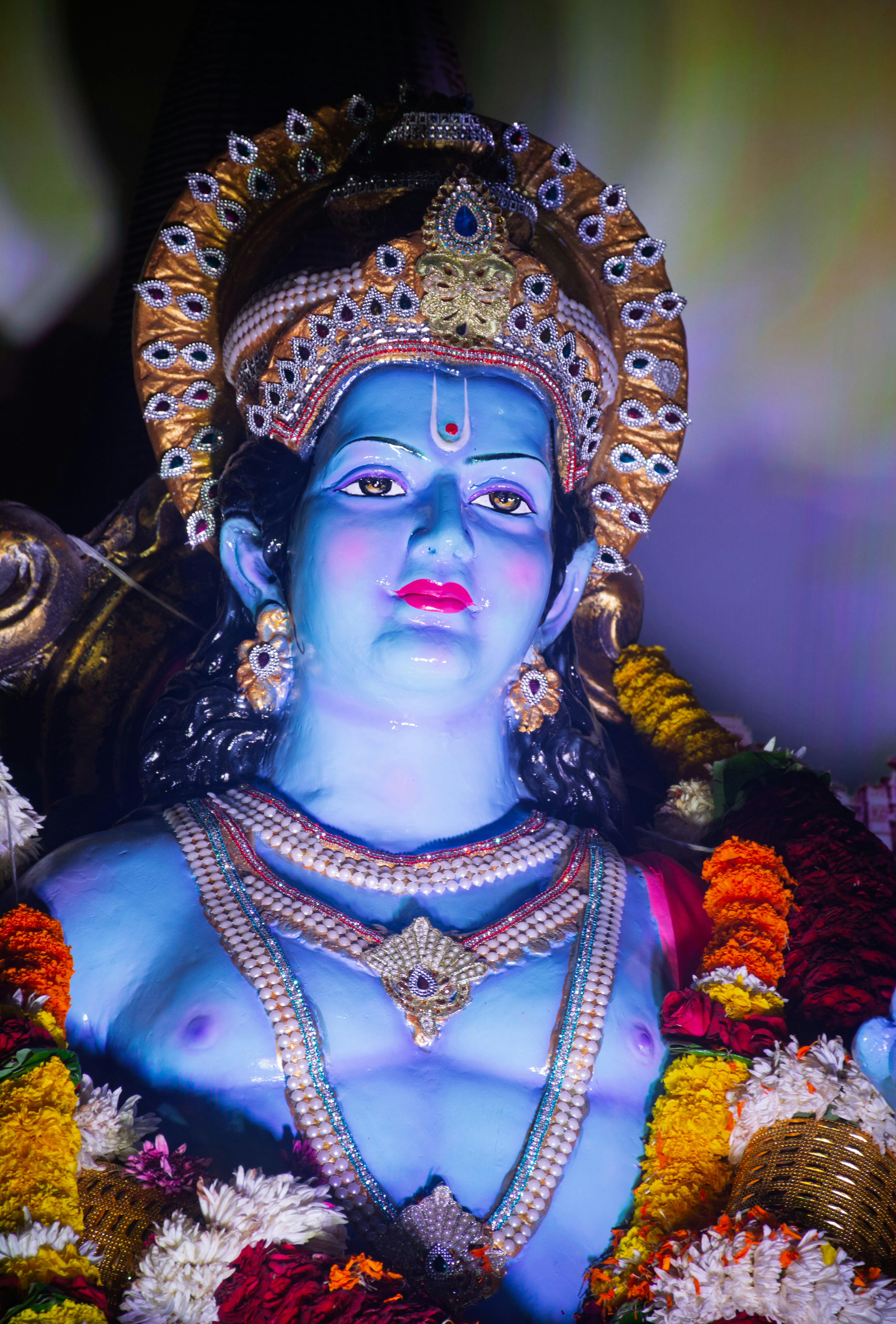 Blue Divinity: A Sacred Bust Adorned in Jewels and Garlands