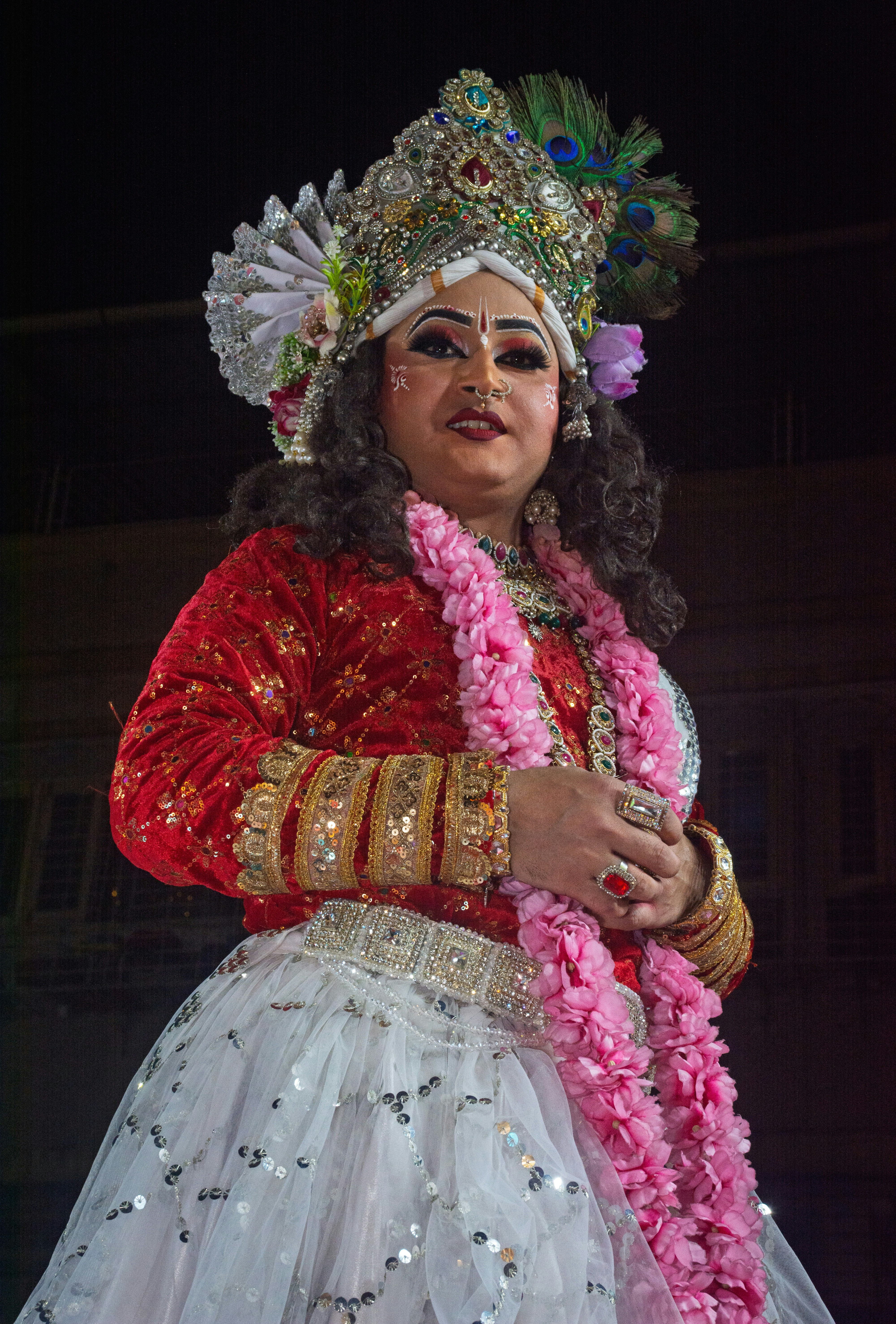 Regal Performer in Ornate Attire with Pink Lei