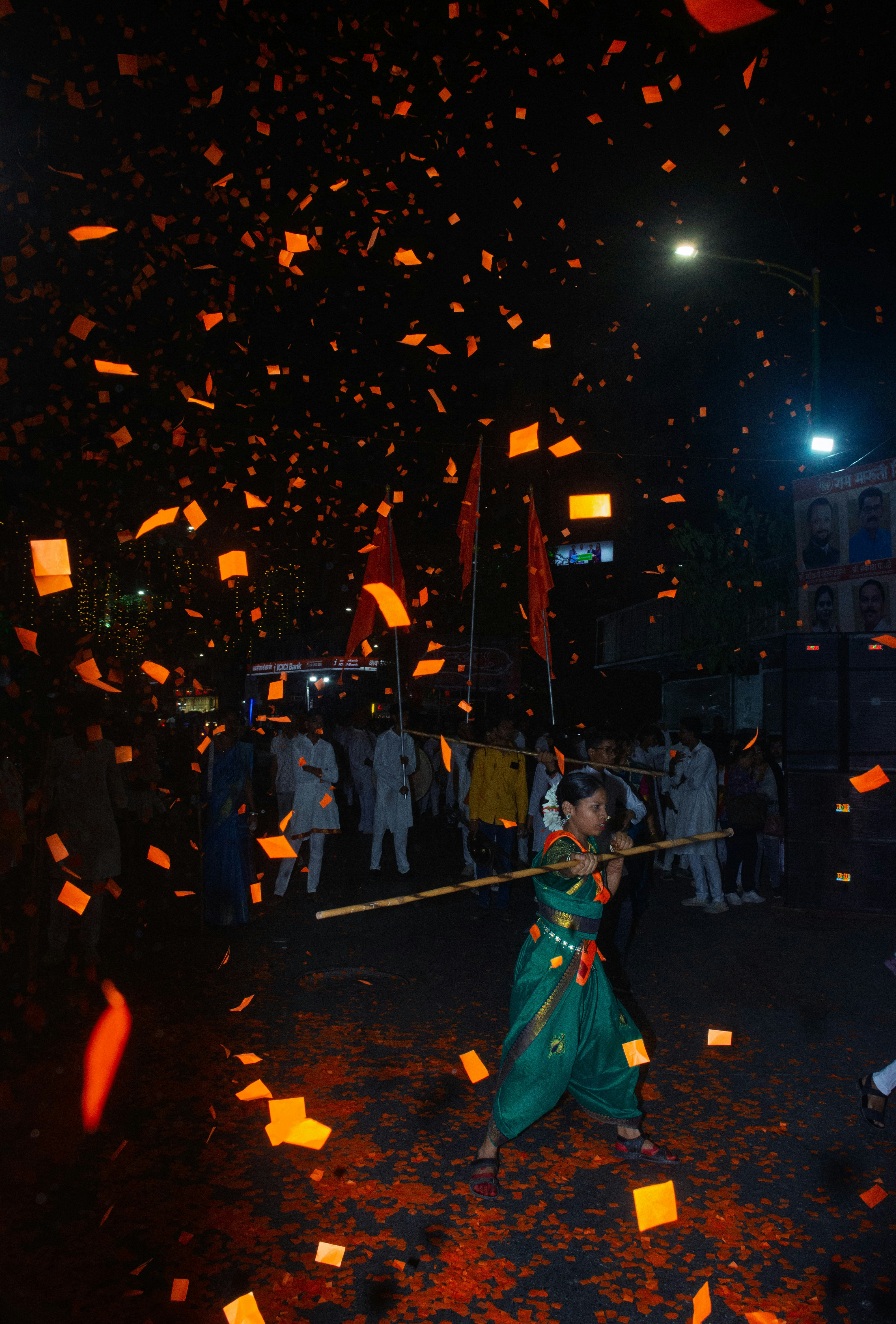 Aurora of Orange Sparks: A Young Performer in a Night Parade