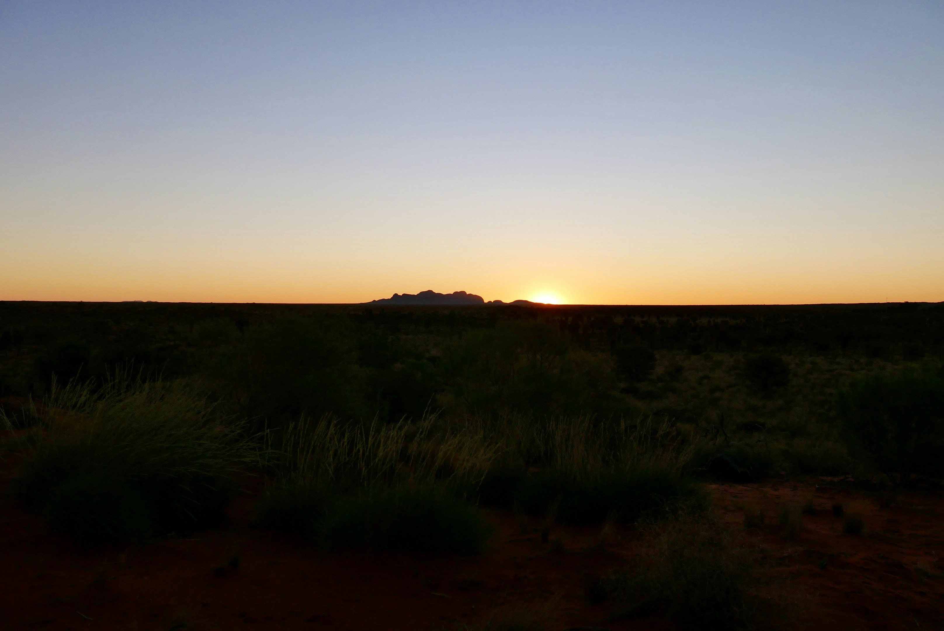 Sunrise on the Plains: silhouette of a distant structure at horizon