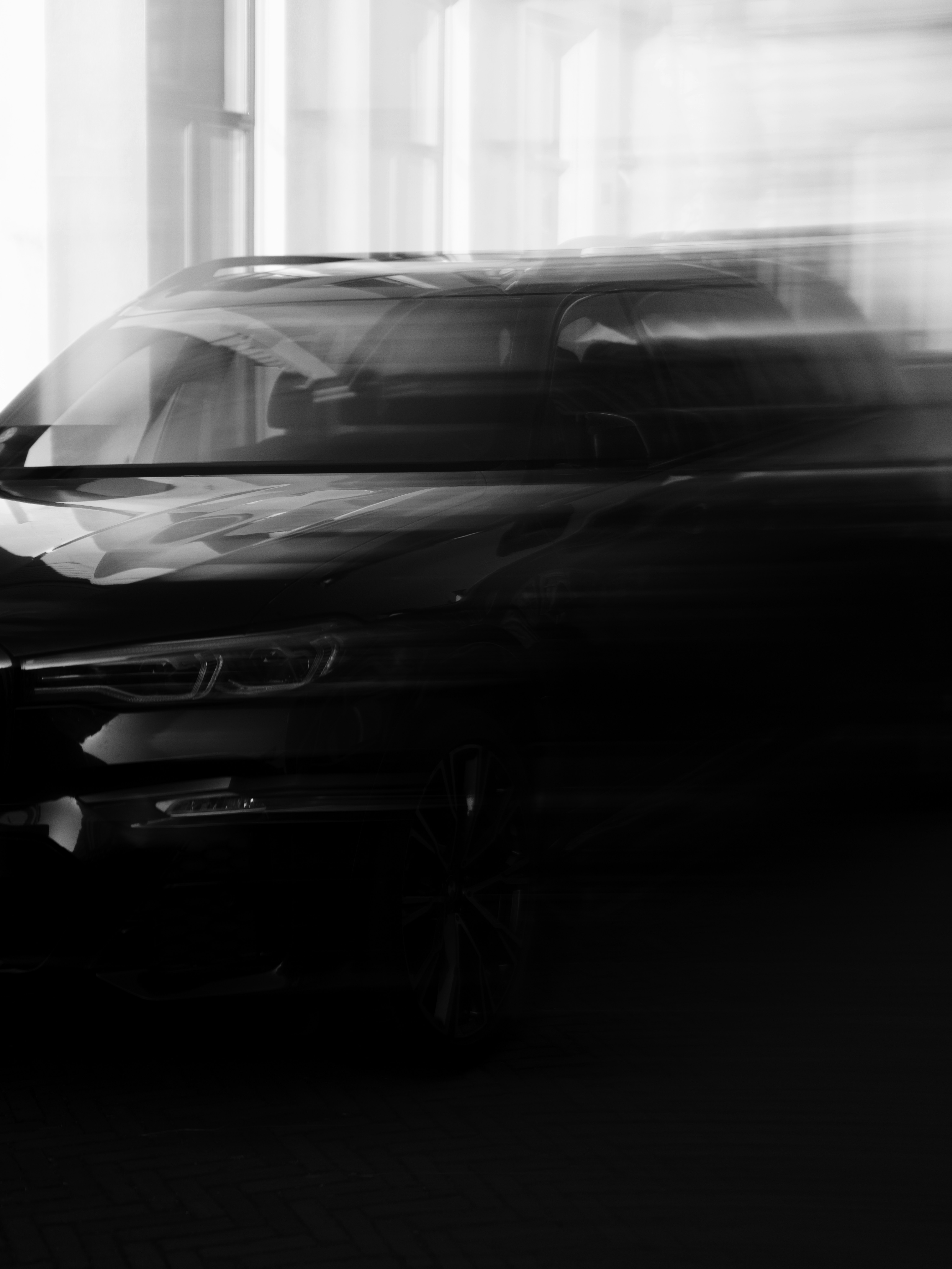 Motion Blur on a Black Car in a Bright Indoor Gallery