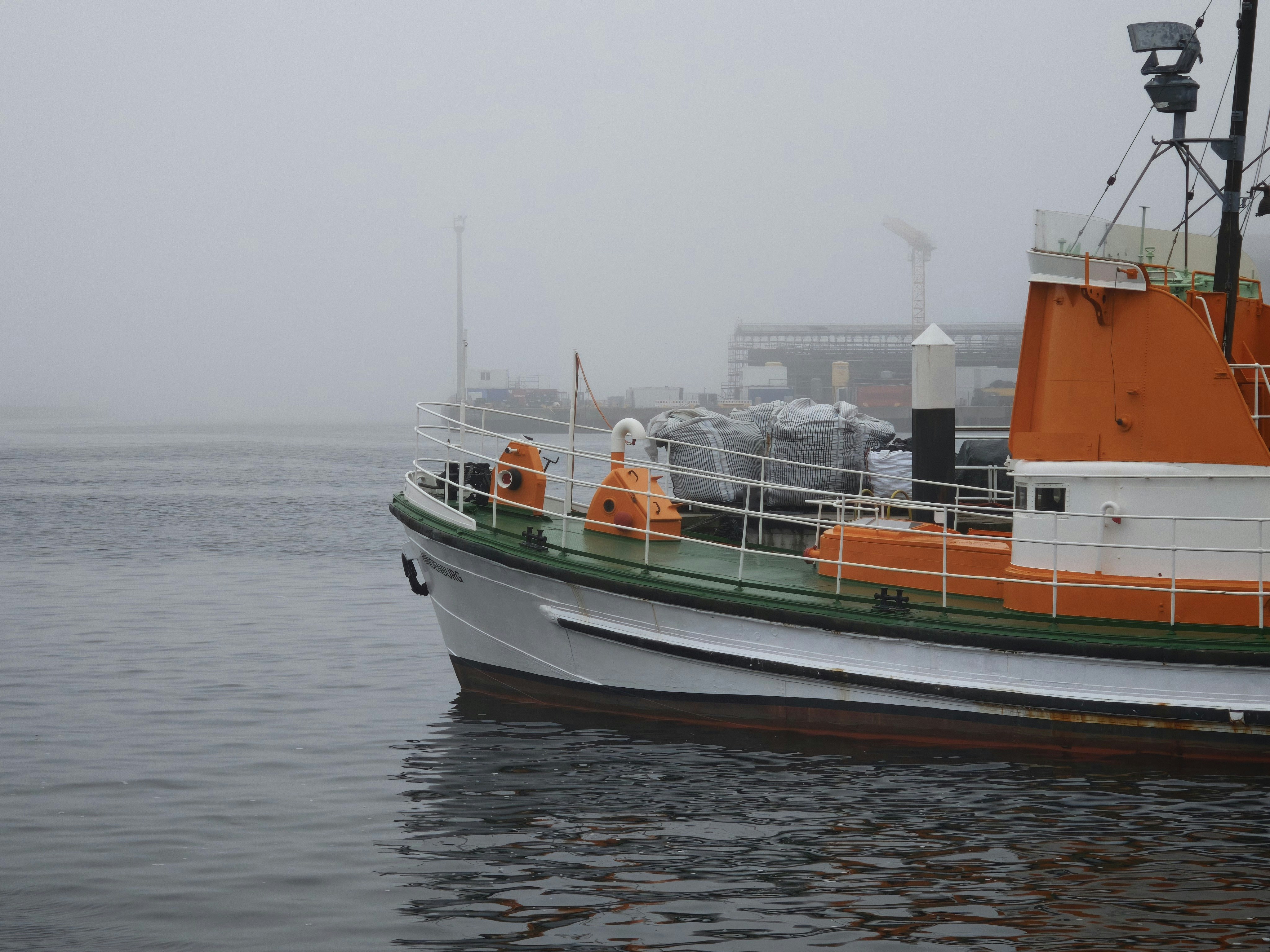 Foggy Harbor: The Bow of a Workboat Surrounded by Quiet Ripples