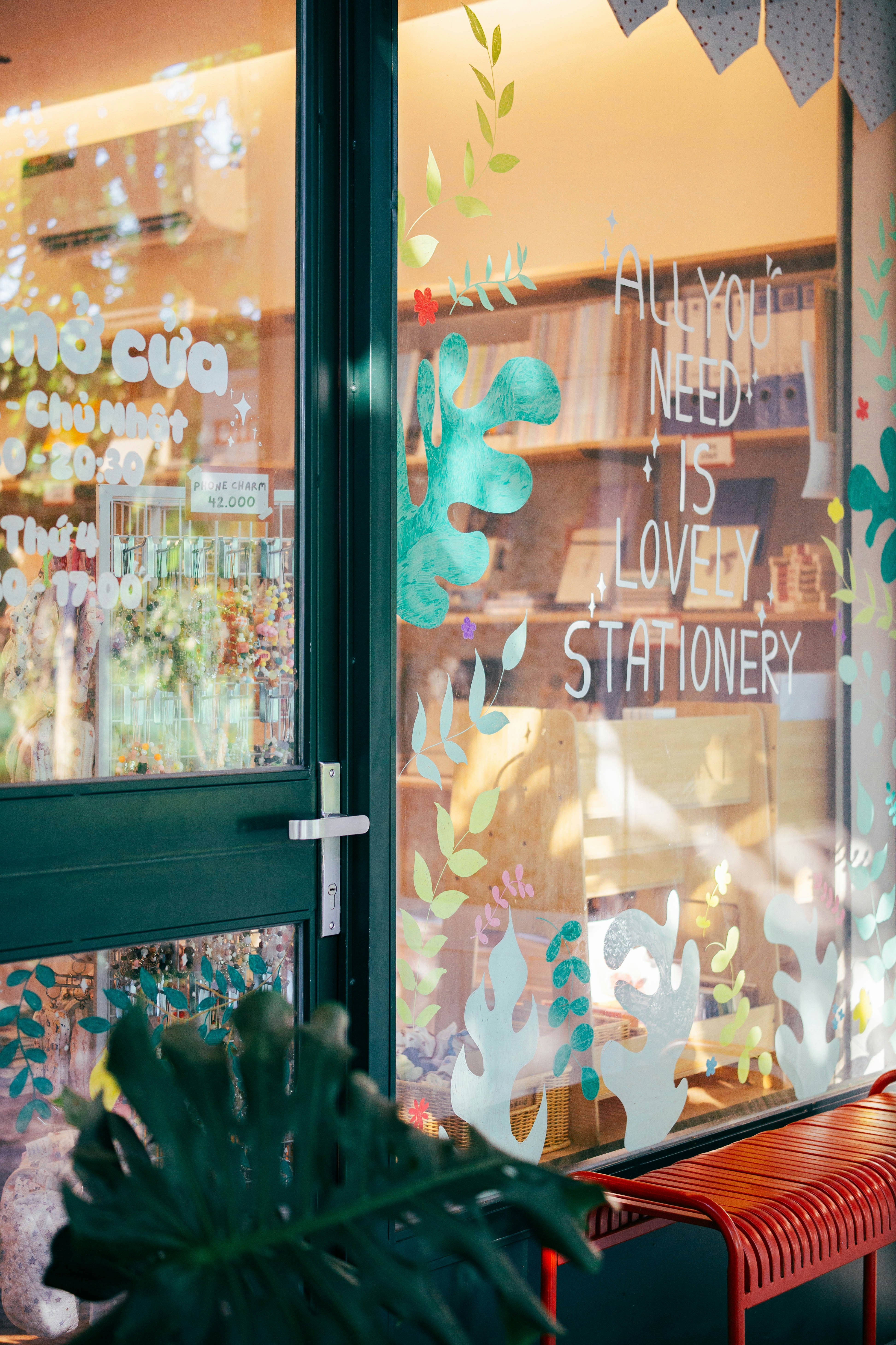 Stenciled welcome: a glass storefront with painted flora and the message All You Need is Lovely Stationery