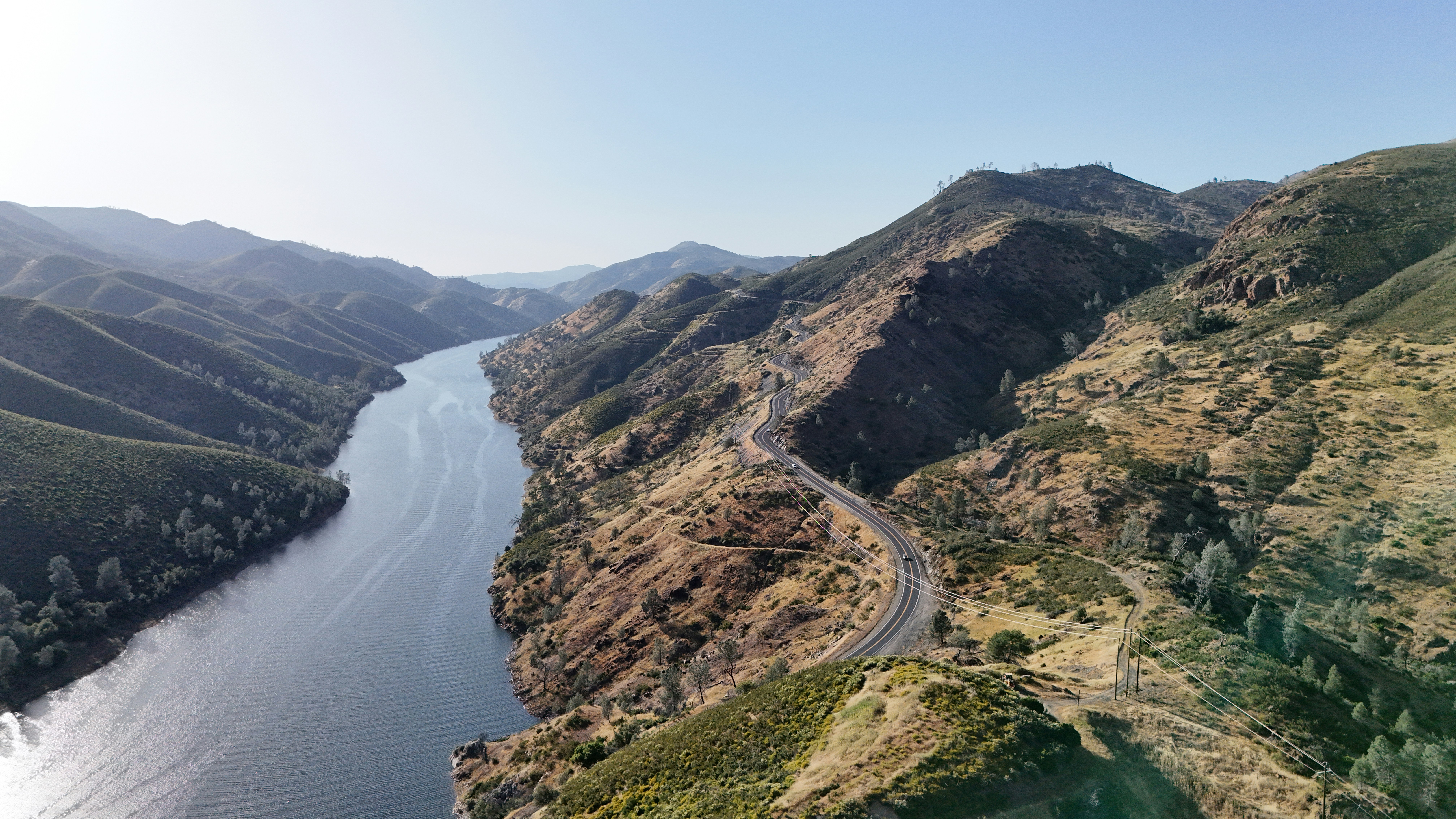 Riverside Serpentine: A Mountain Road Guarded by Light