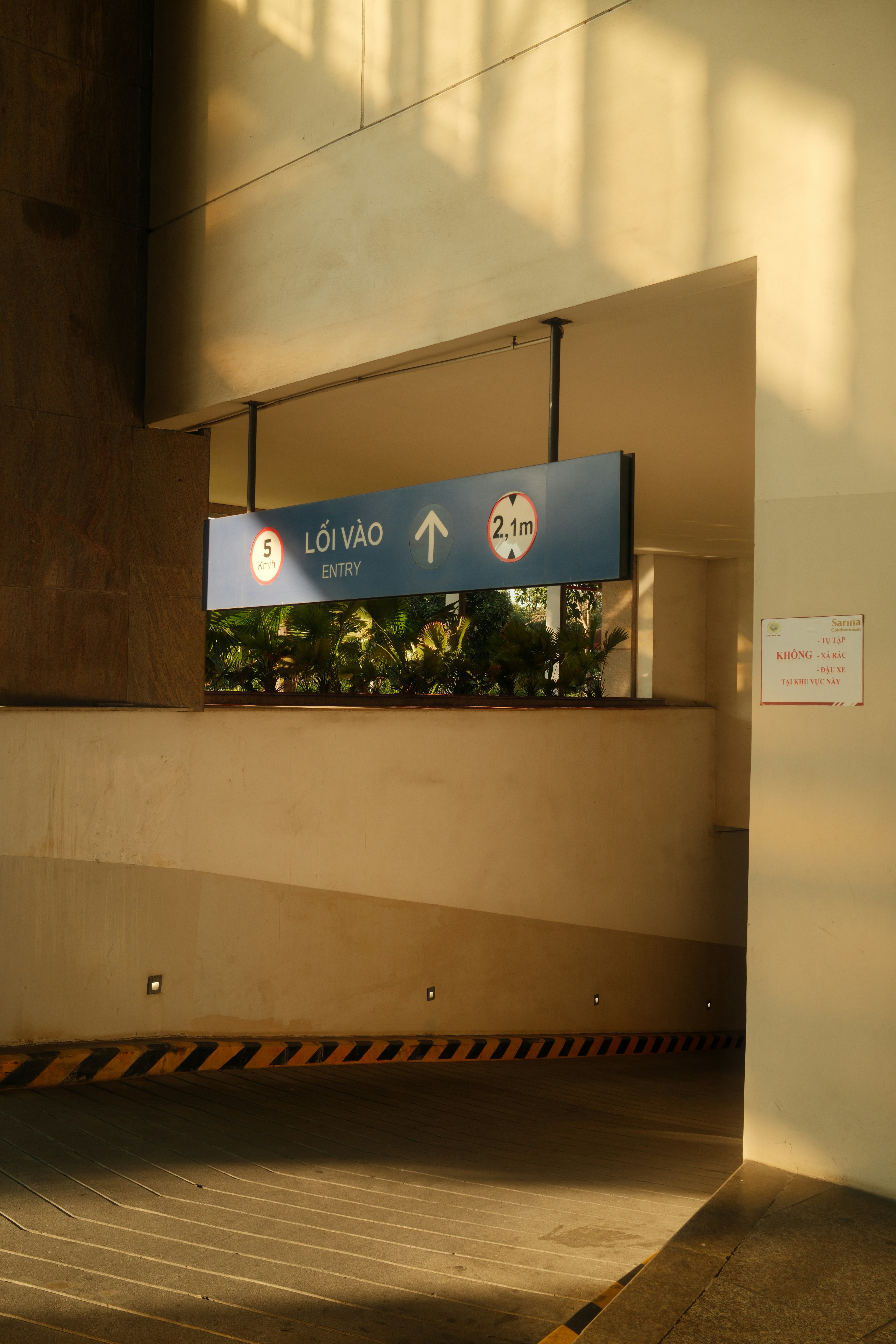 Sunlit Entrance: Shadowed Ramp Beneath the Sign