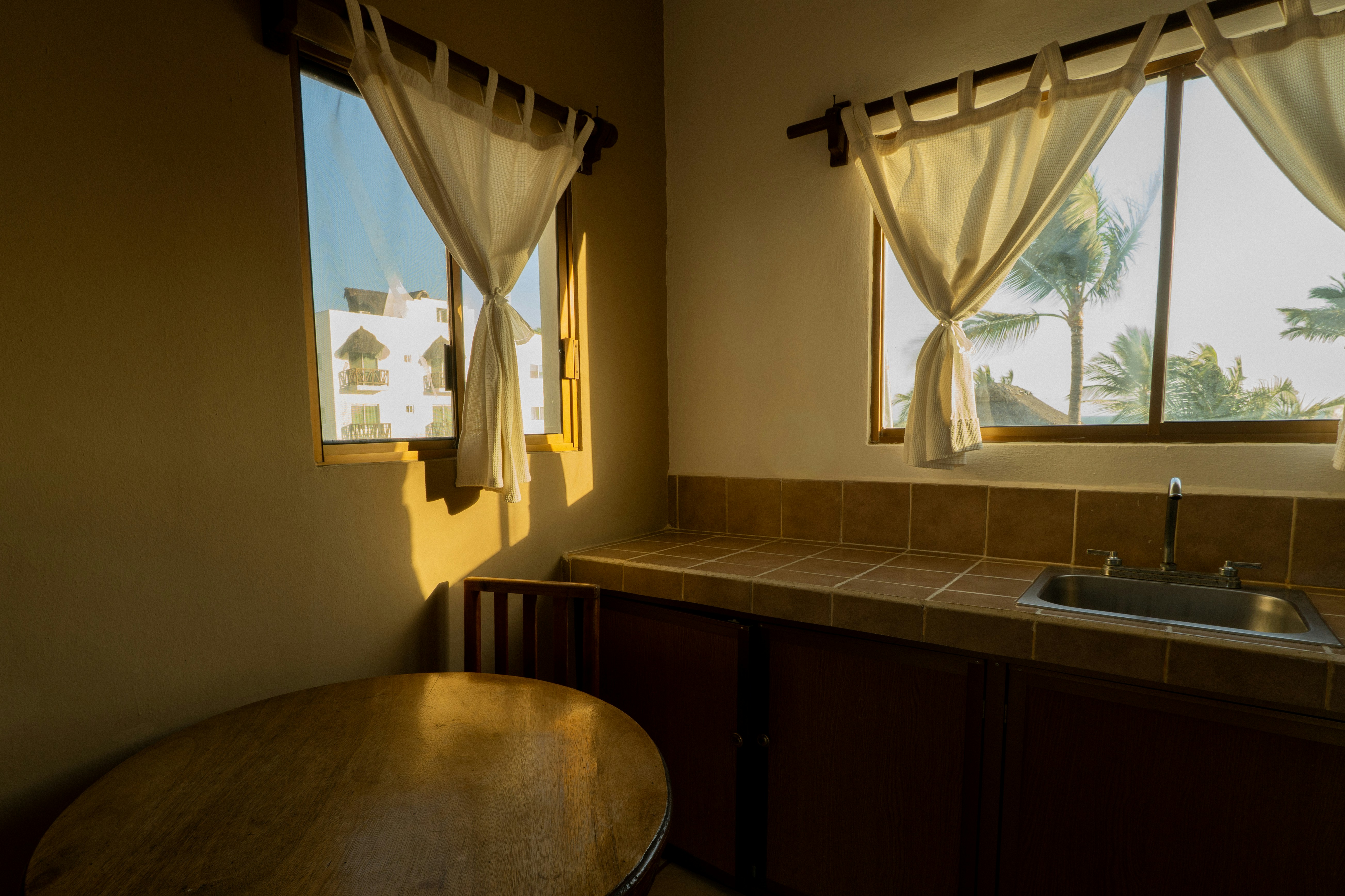 Sunlit Kitchen Nook with Warm Wooden Table and Bright Windows