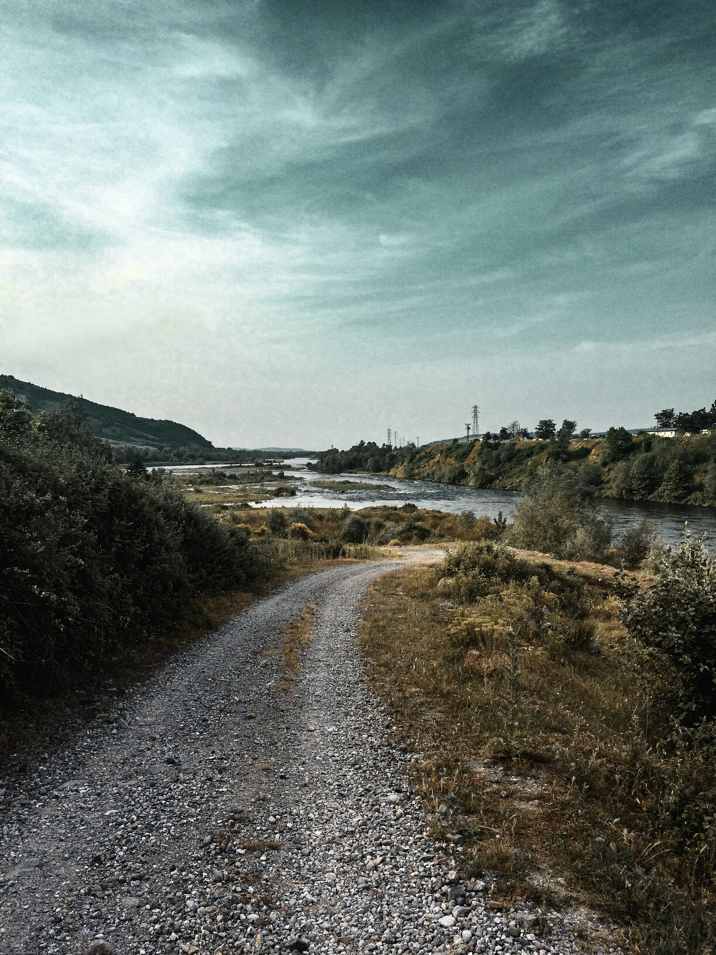 Rugged Riverside Path Bending Toward Distant Hills