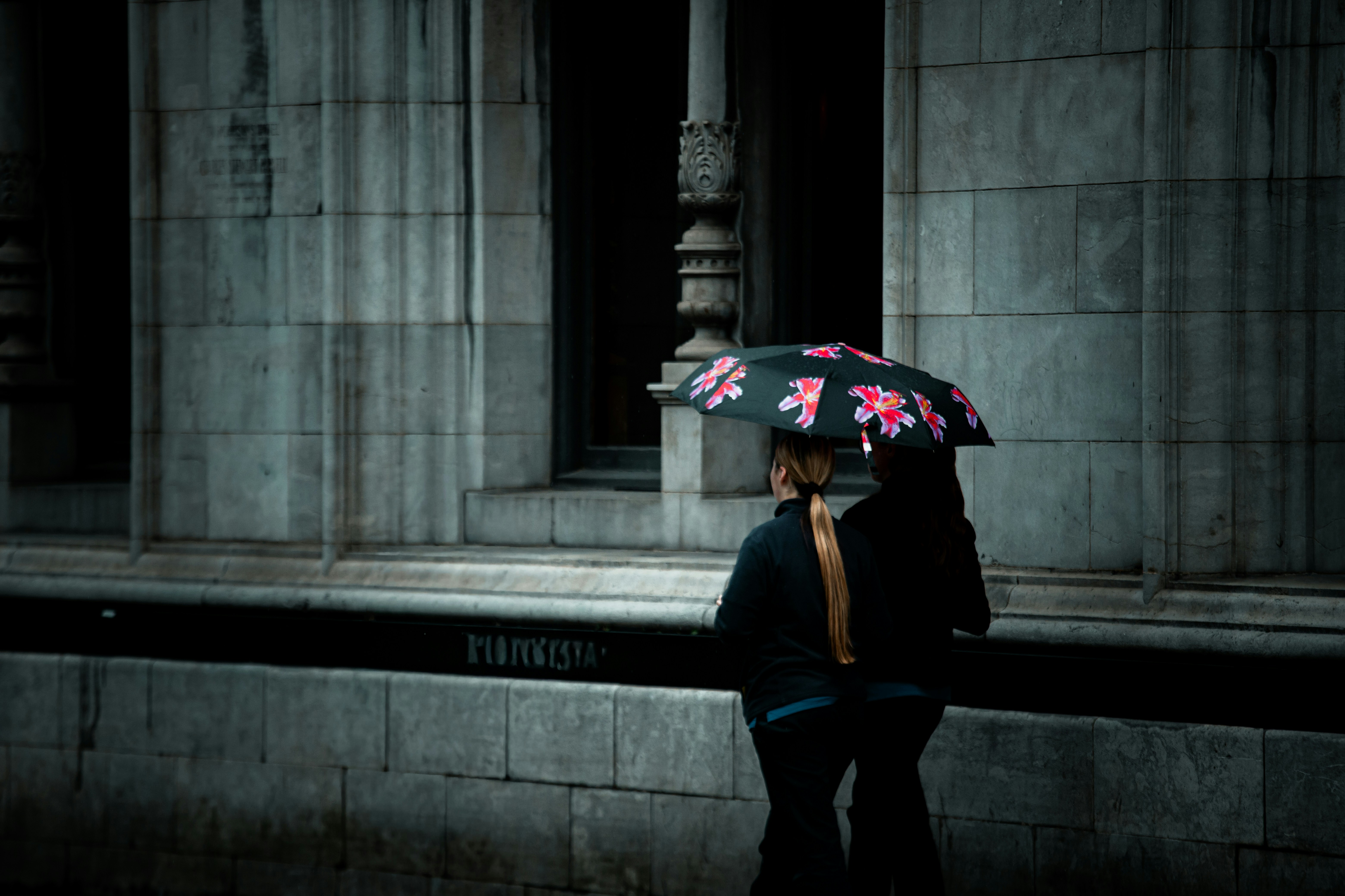 Umbrella Bloom: Quiet Moment by the Carved Stone Wall