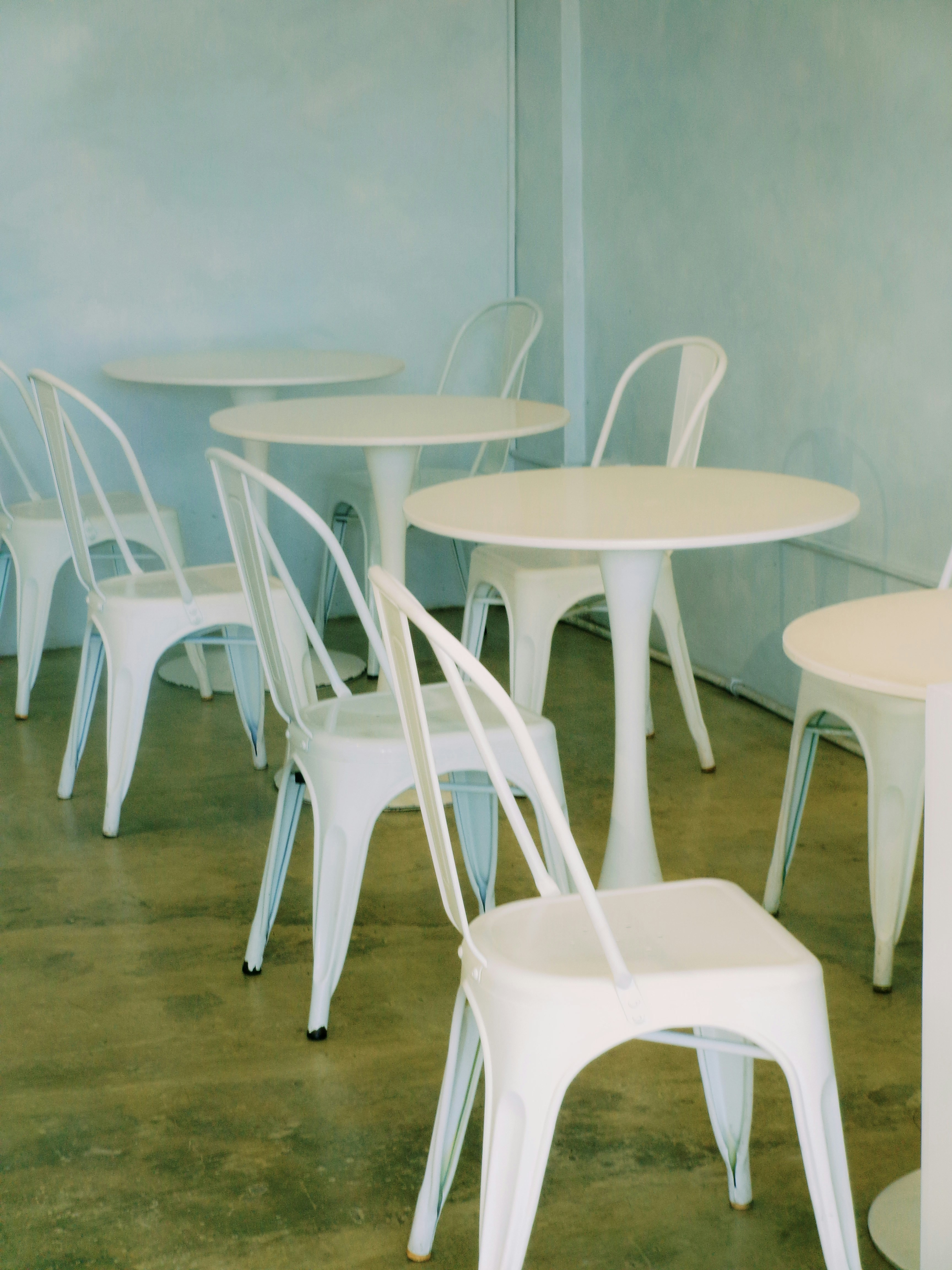Pastel Silence: A Quiet Café Corner with White Metal Chairs