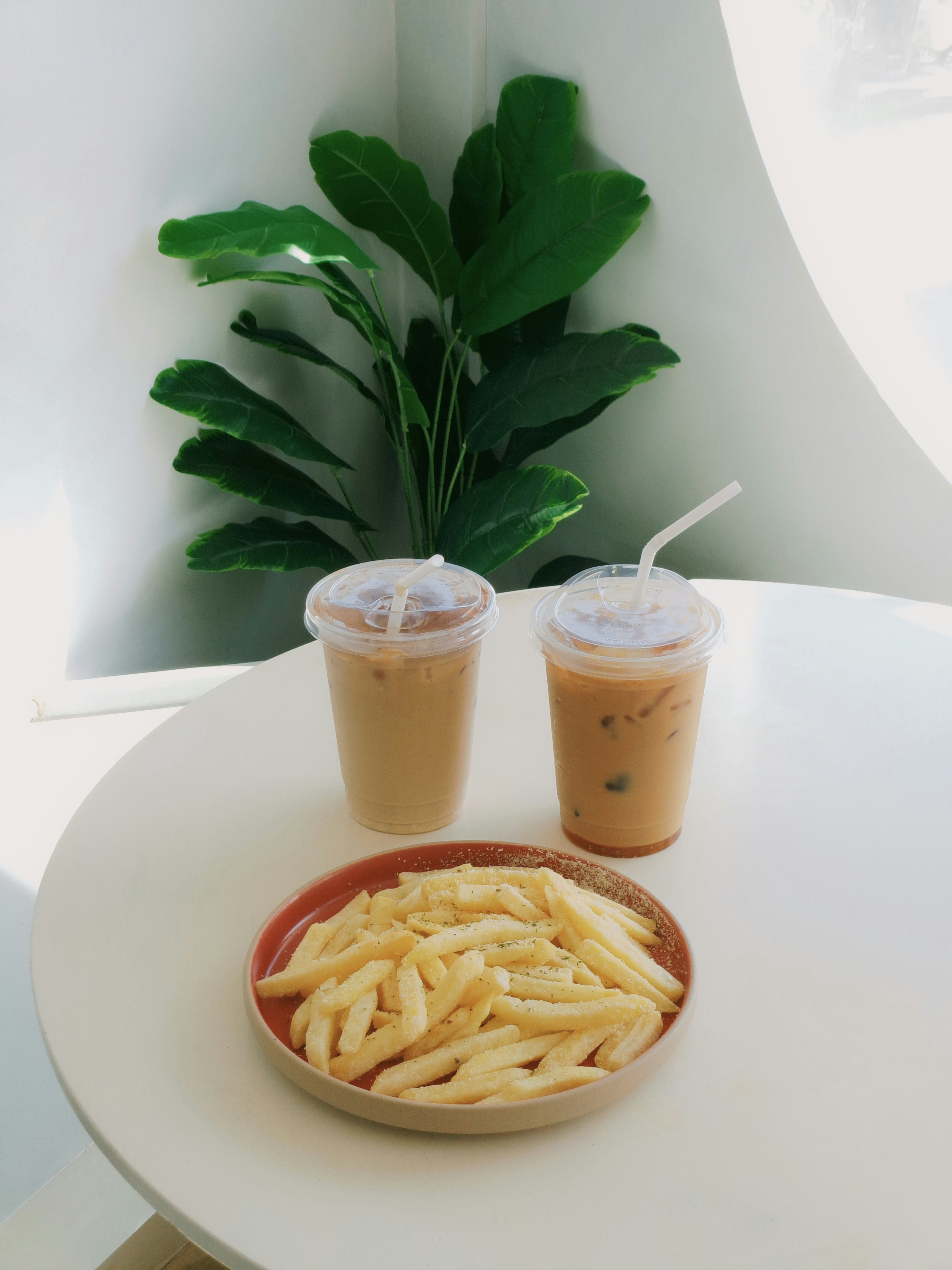 Strawberry Iced Coffee and Fries on a Sunlit Table