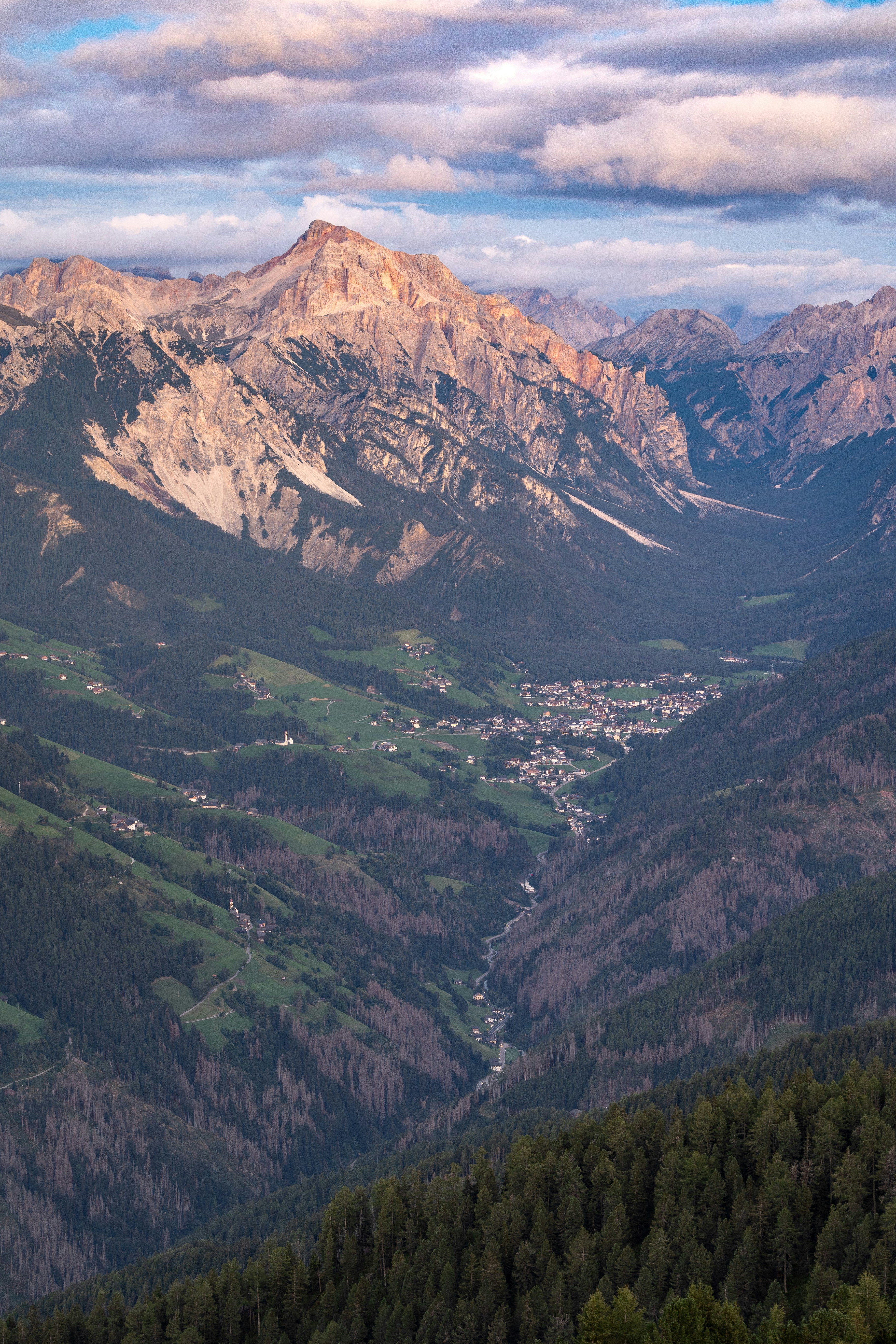 Sunlit Alpine Peak Over a Valley of Greens
