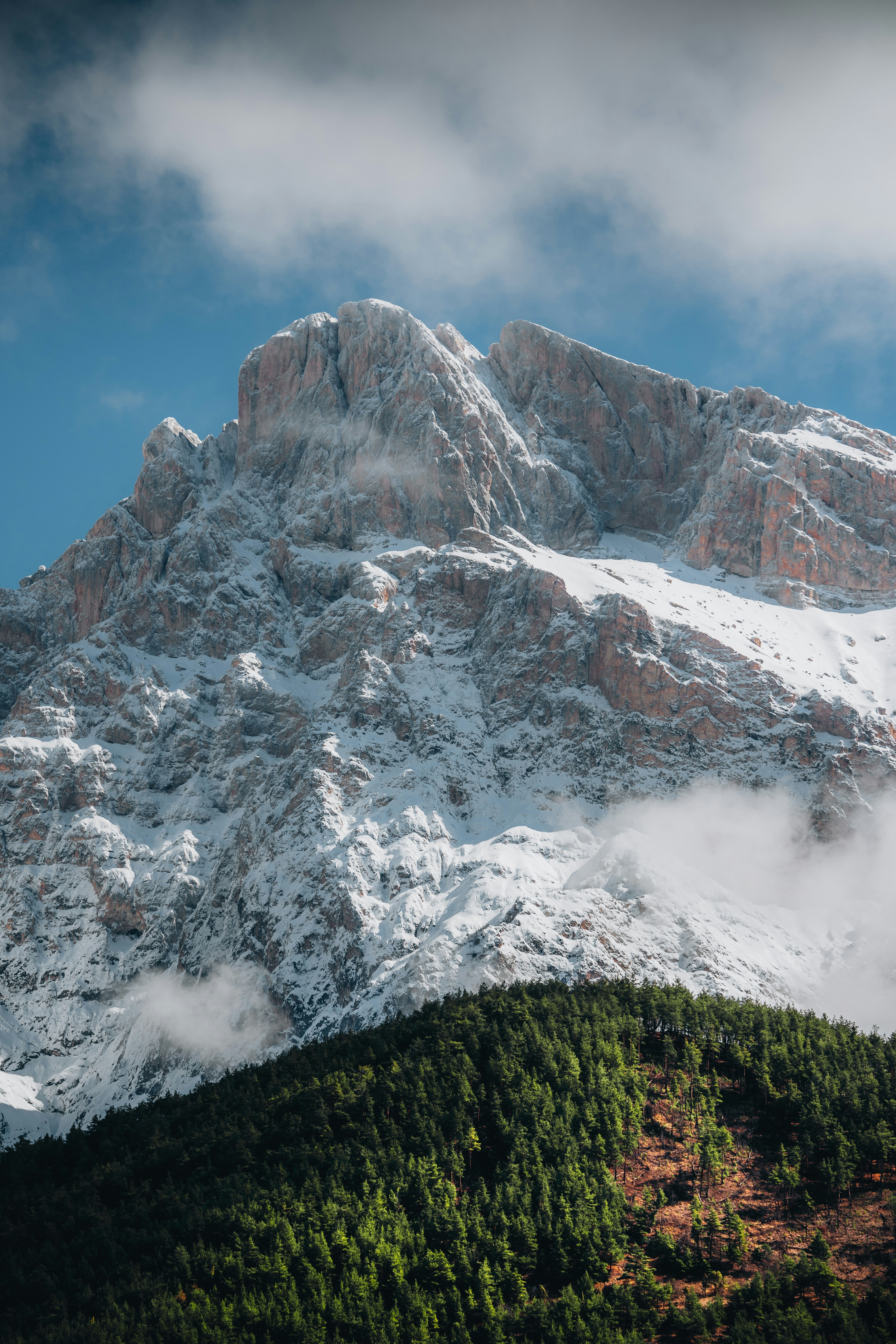 Sum of Peaks: Snow-Glazed Summit Under Blue Sky