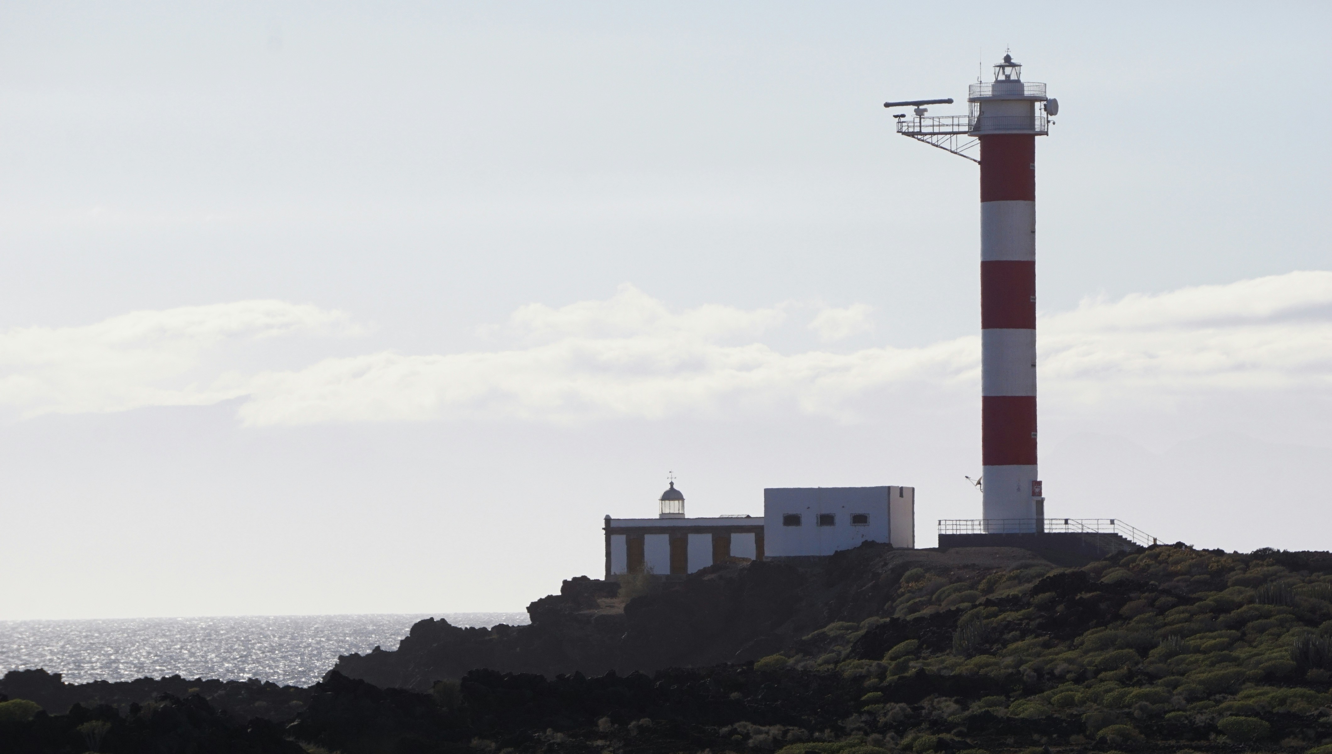 Coastal Beacon: The Red-White Stripes Stand Guard Over Quiet Seas