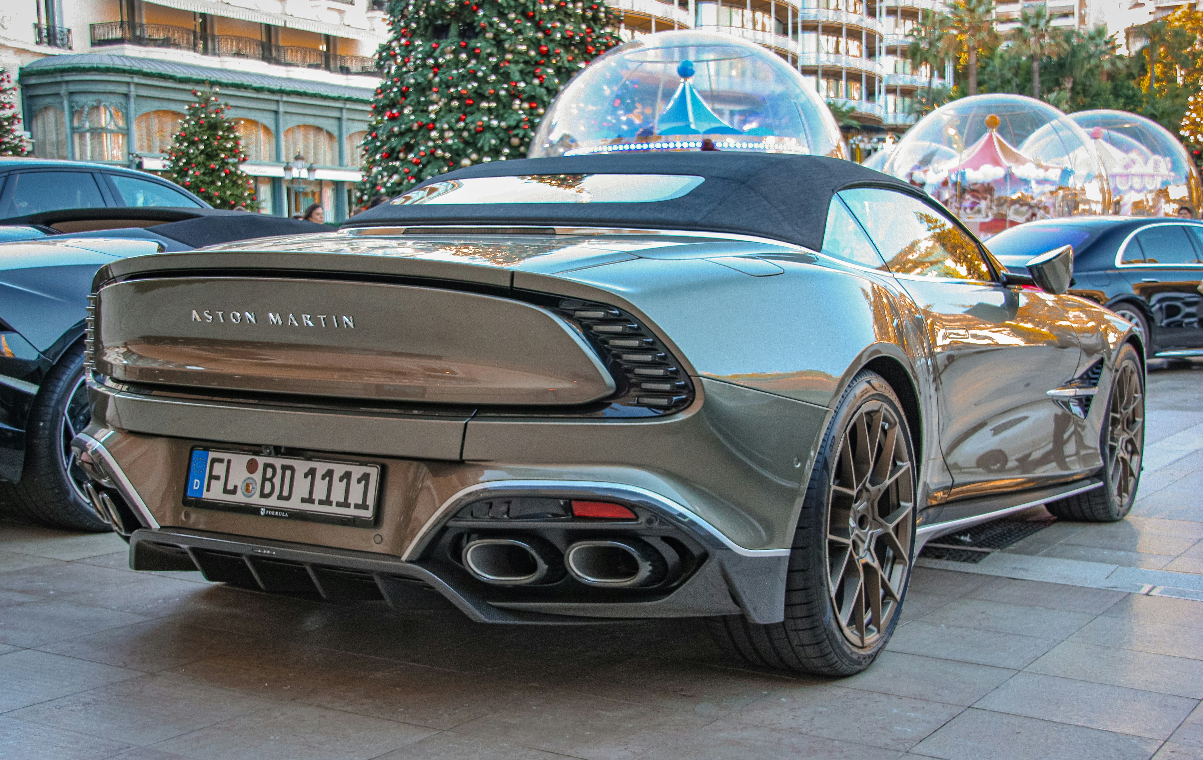 A glossy Aston Martin at dusk: sports car under festive arcades