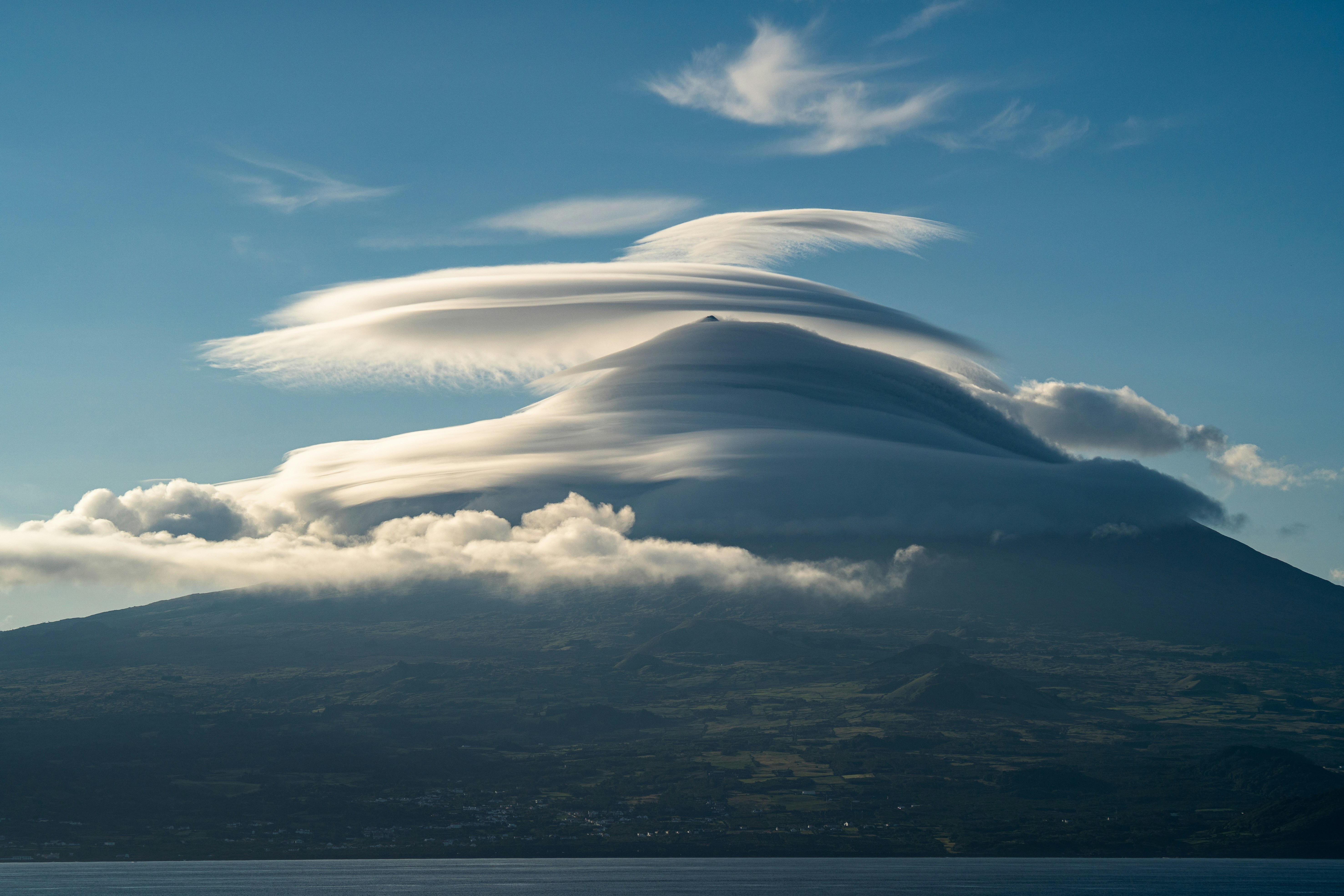 Lenticular Summit: A Tiered Cloud Monolith Above the Caldera