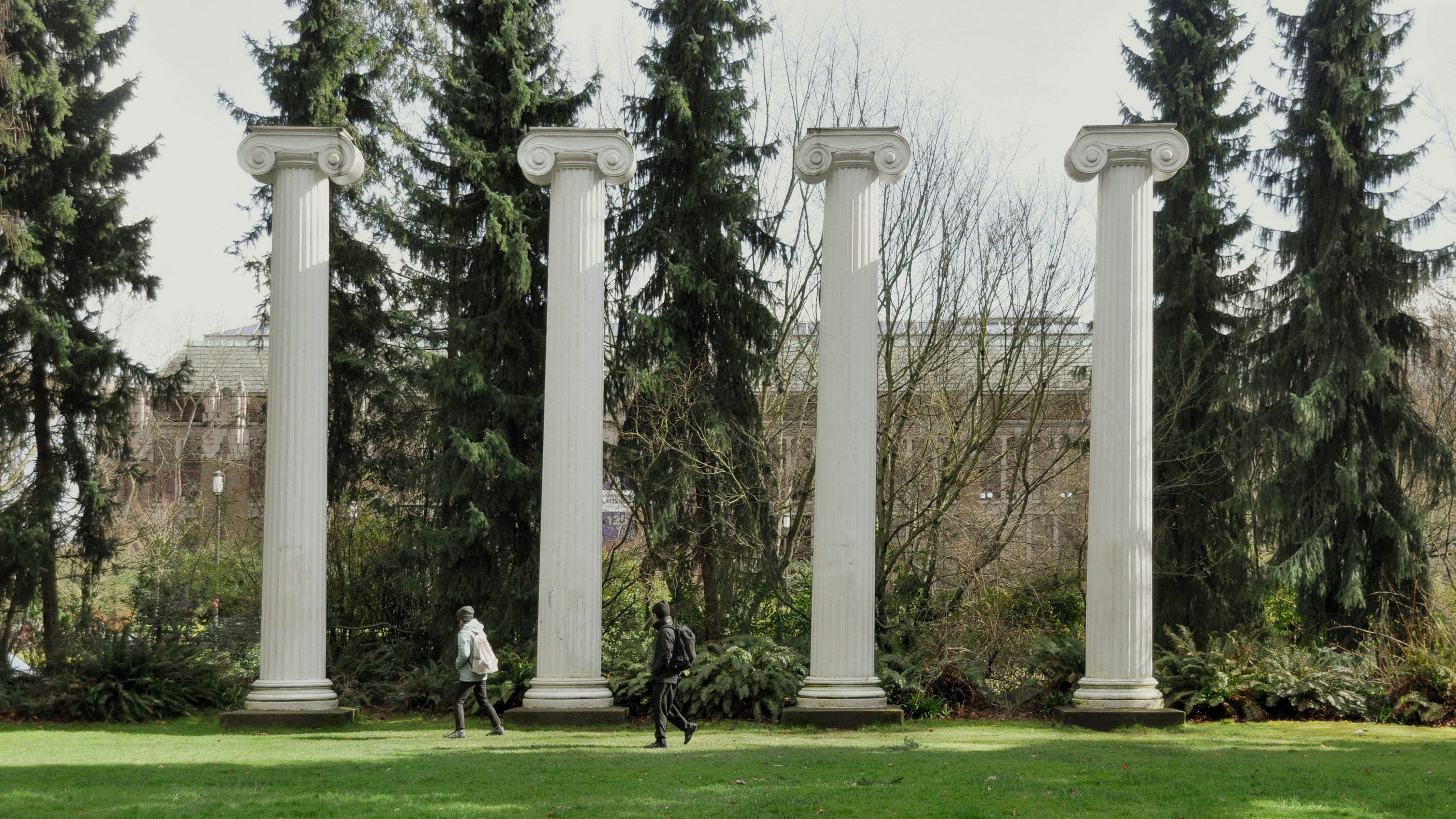 Columns in the Courtyard Garden: Two Visitors Passing Between Classical Pillars