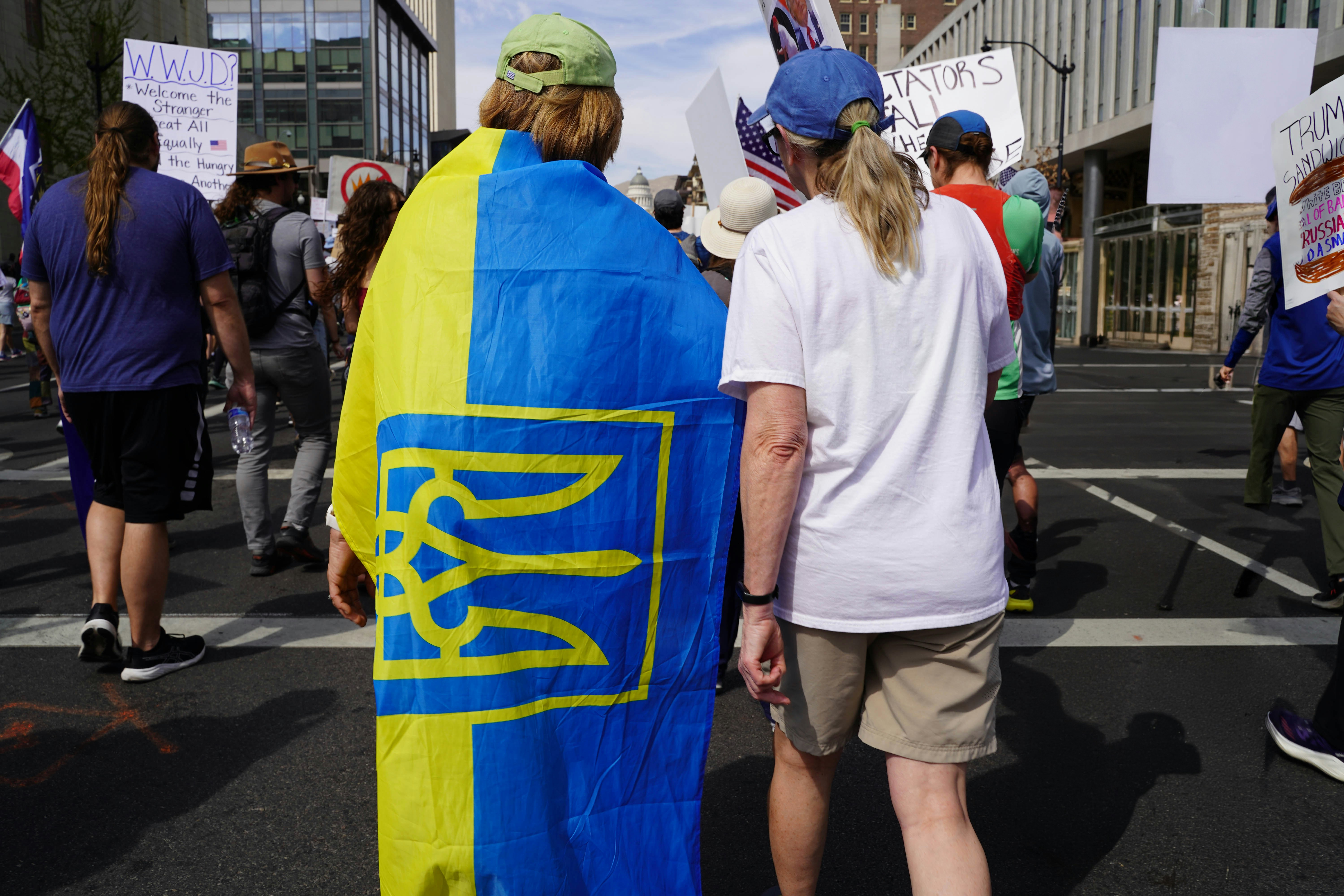 Flag-wrapped Protester and White-T-shirt Observer in City March