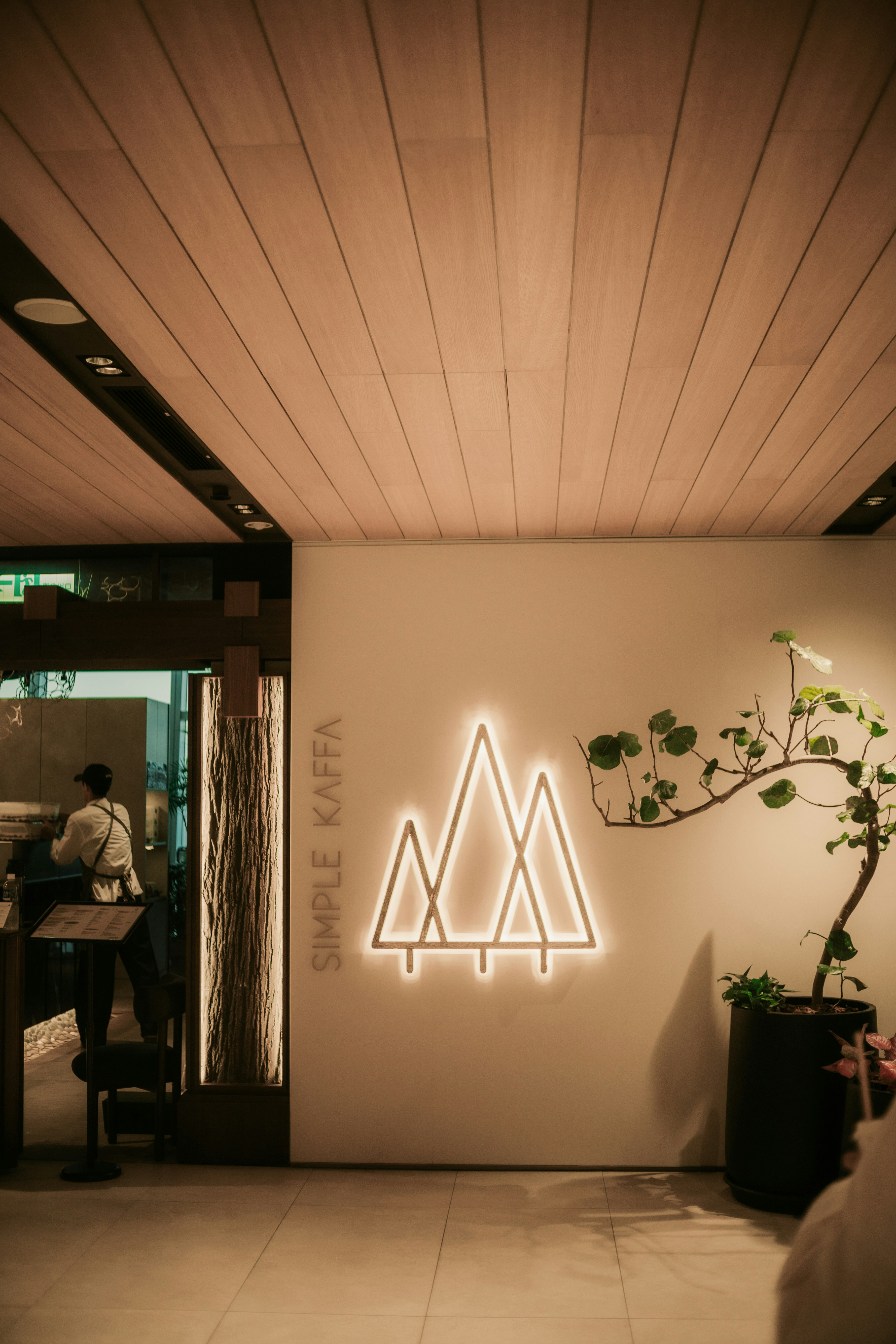 Neon Mountain Logo Illuminates a Minimal Café Hall