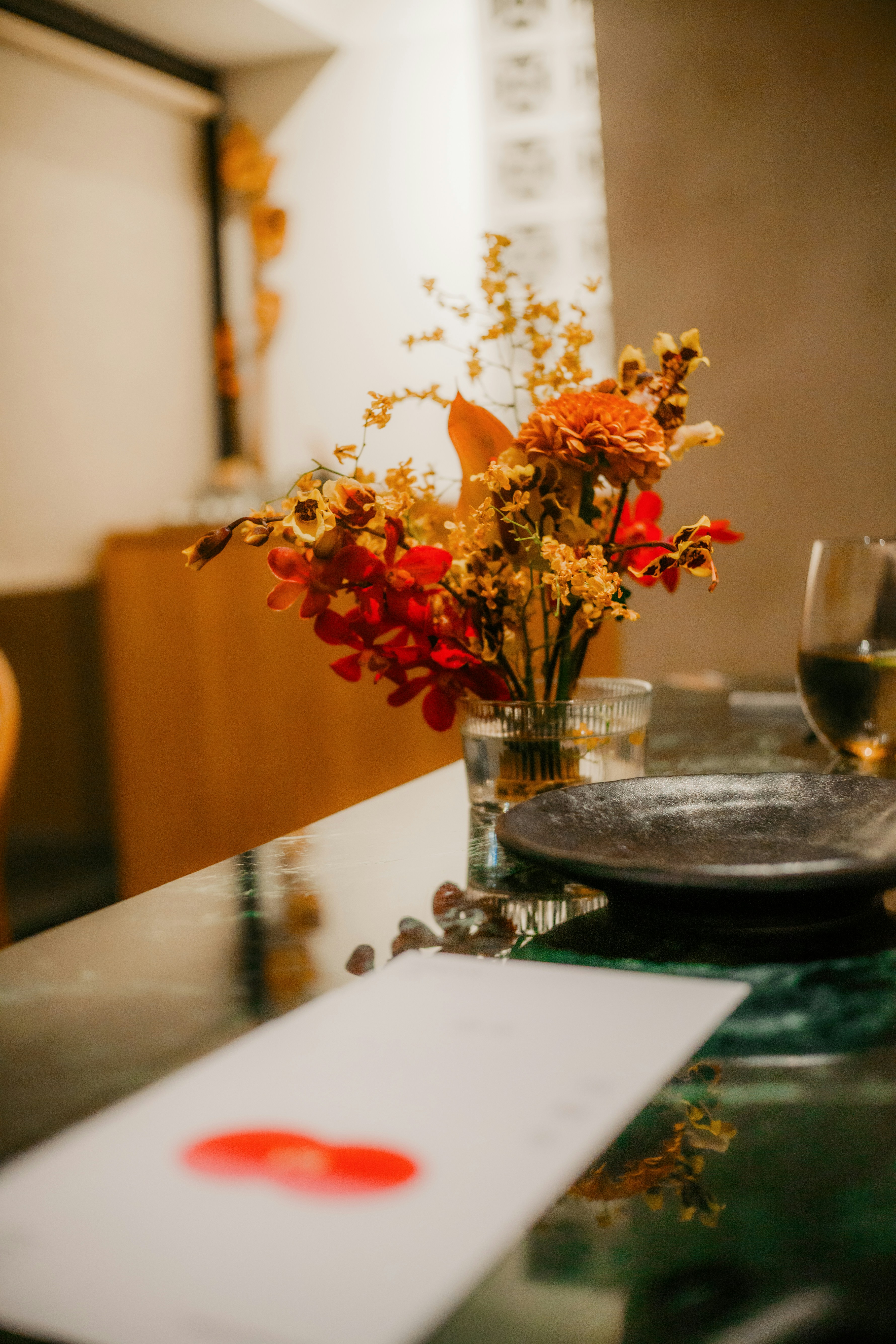 Floral centerpiece and dinner setting on a glossy table