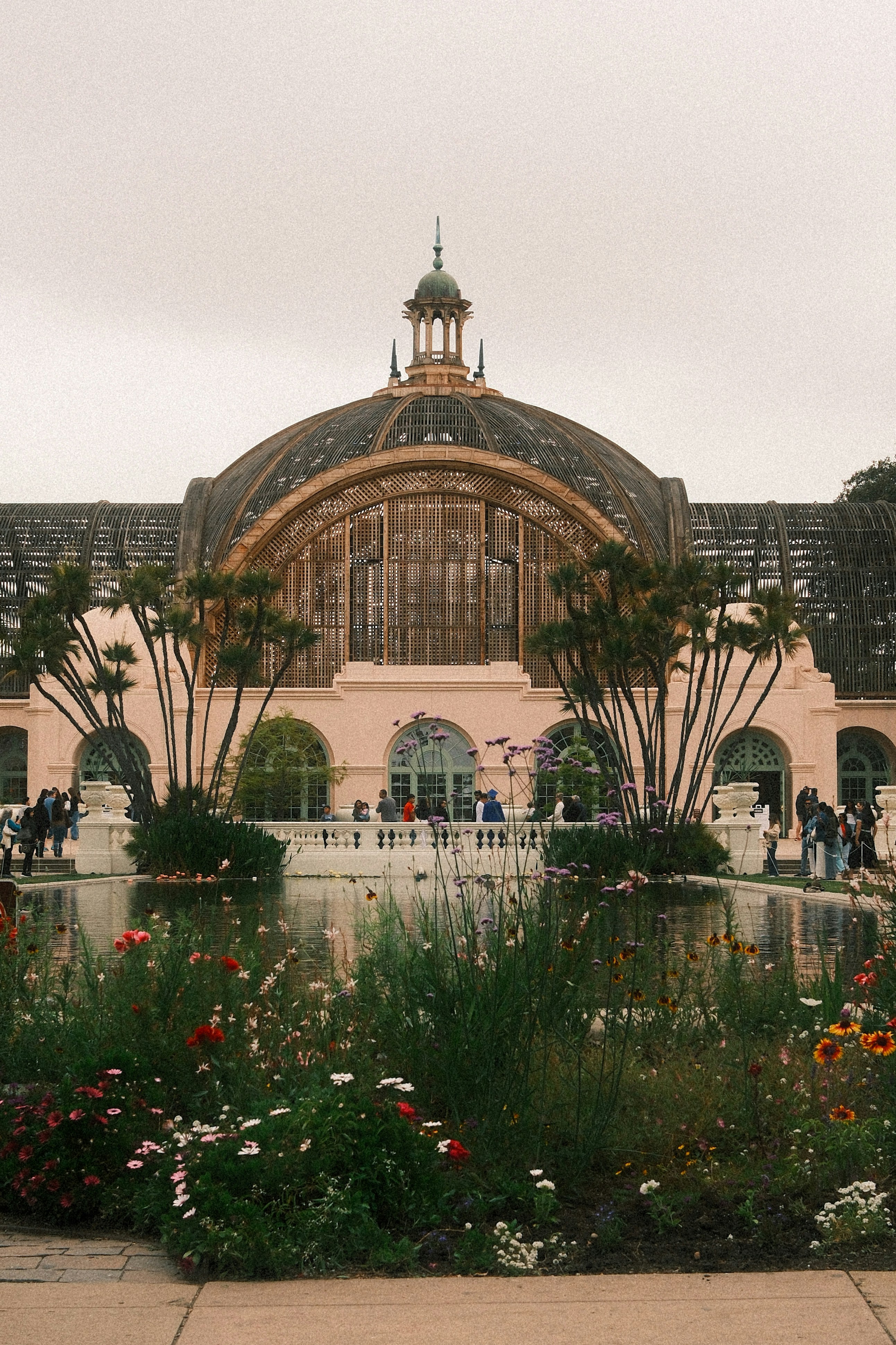 Glasshouse Sunrise: The Conservatory’s Central Dome Rising Over a Flower-filled Courtyard