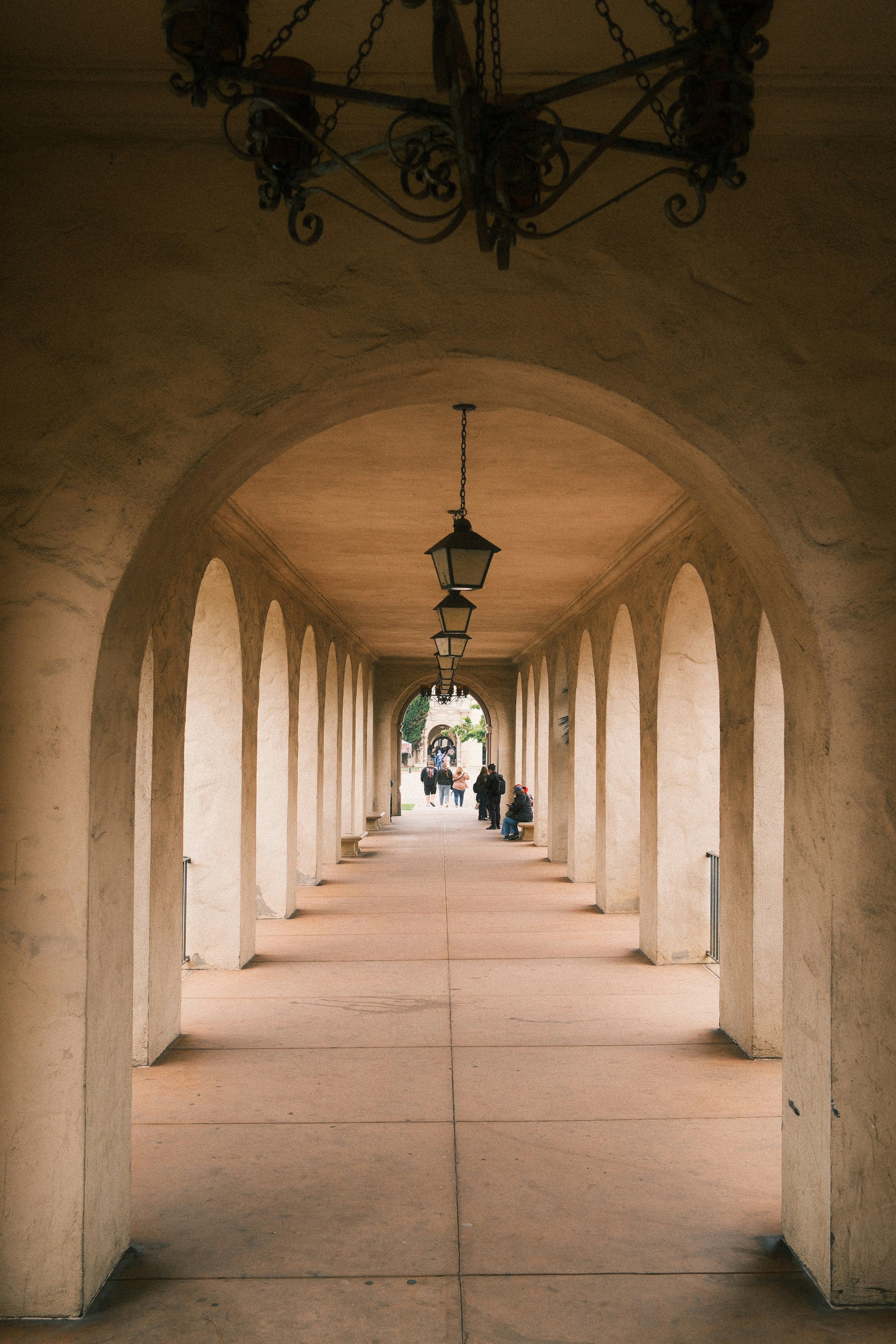 Past the Archway: Sunlit Corridor of Arches and Lanterns
