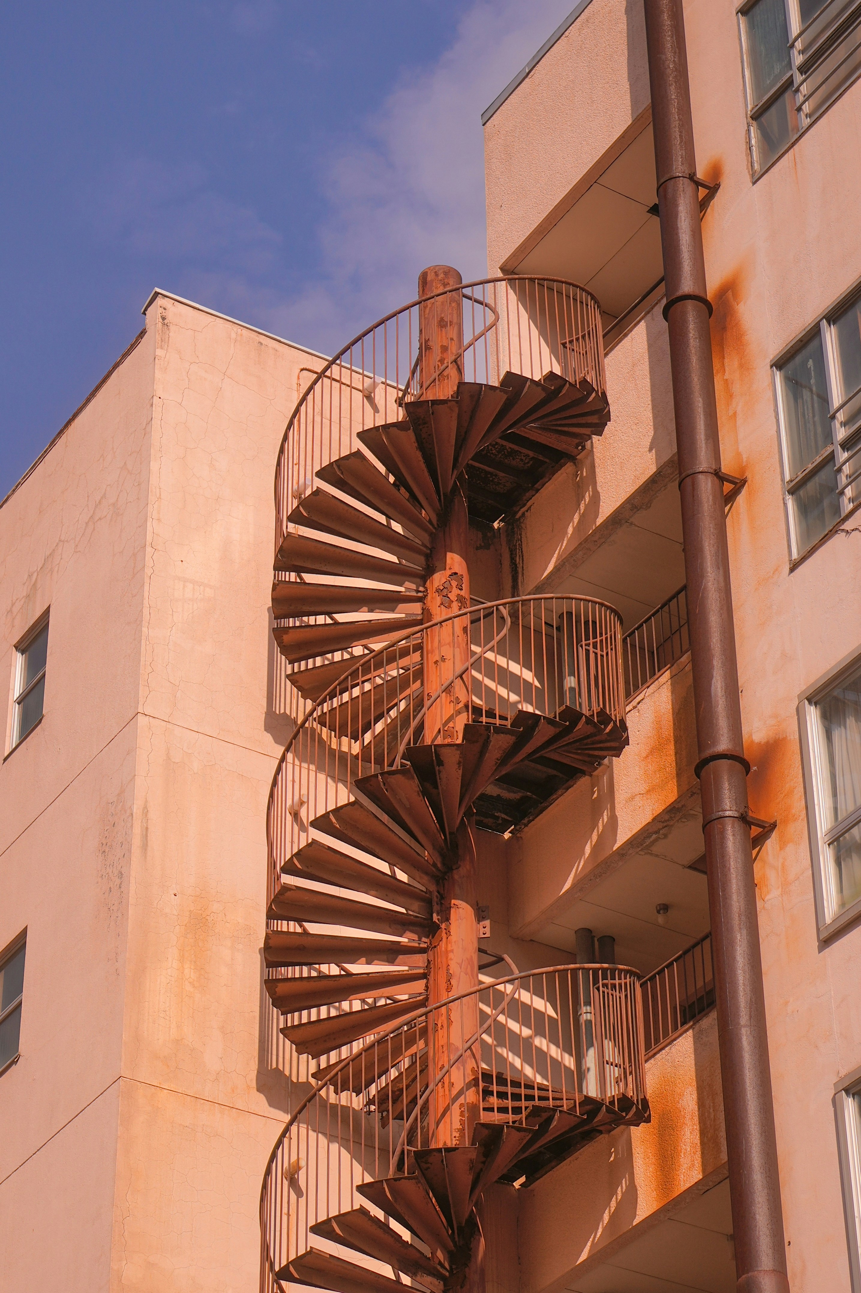 Spiral Staircase Bounded by Sunlit Facade
