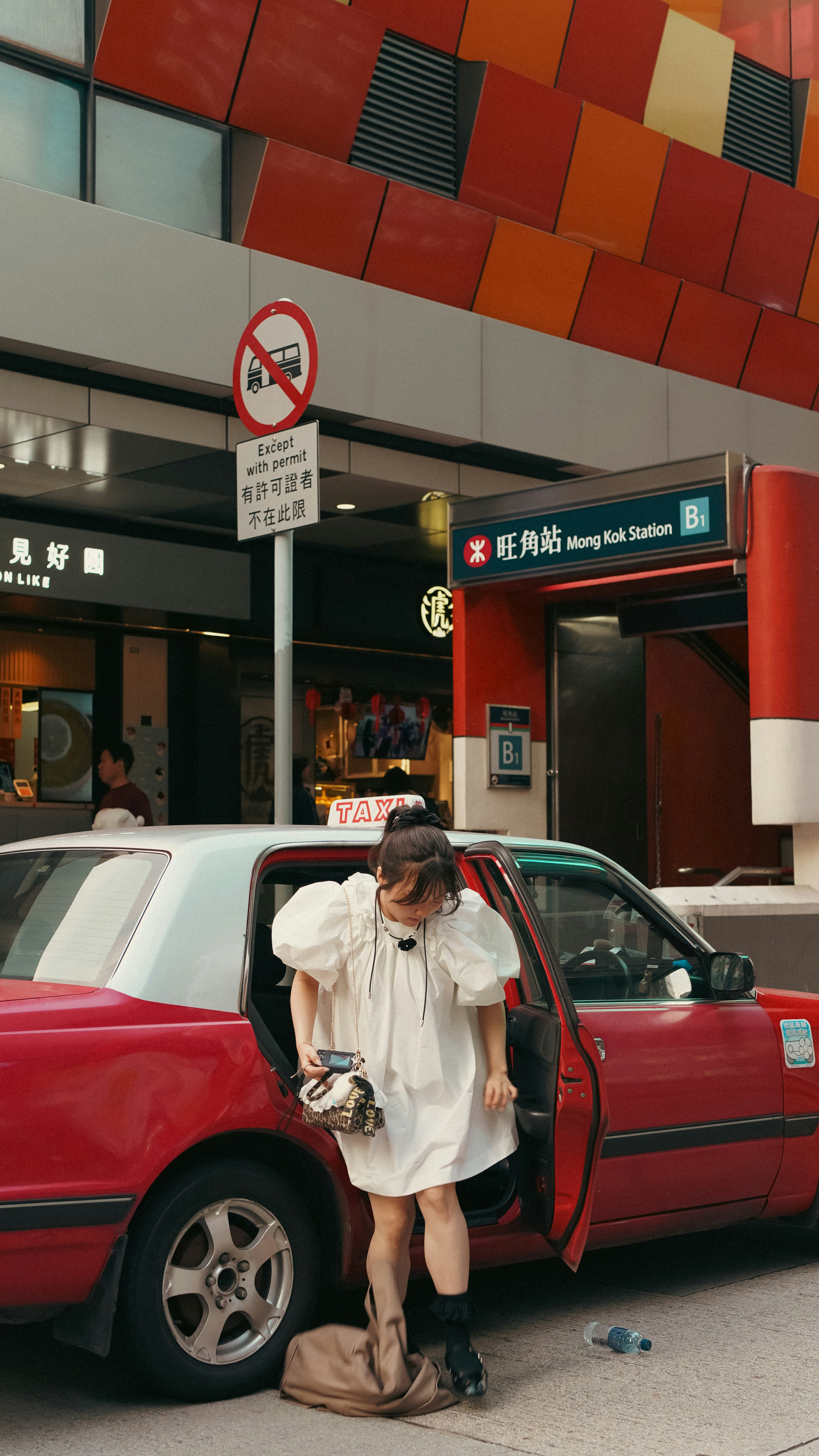 Cityscape taxi exit: a woman stepping from a red cab under colorful architecture