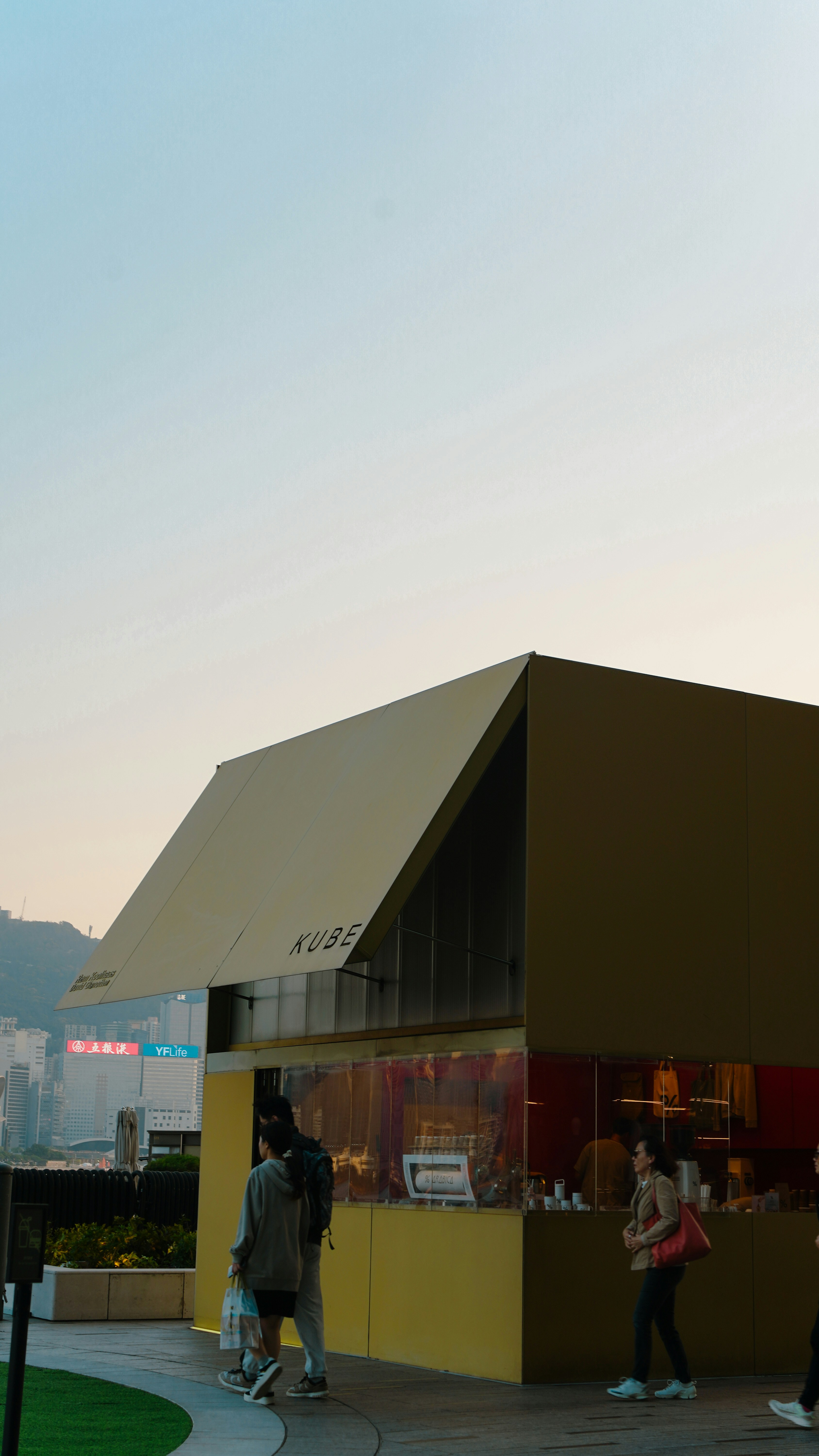 Yellow Pavilion at Dusk: A Casual Moment by the Modern Café
