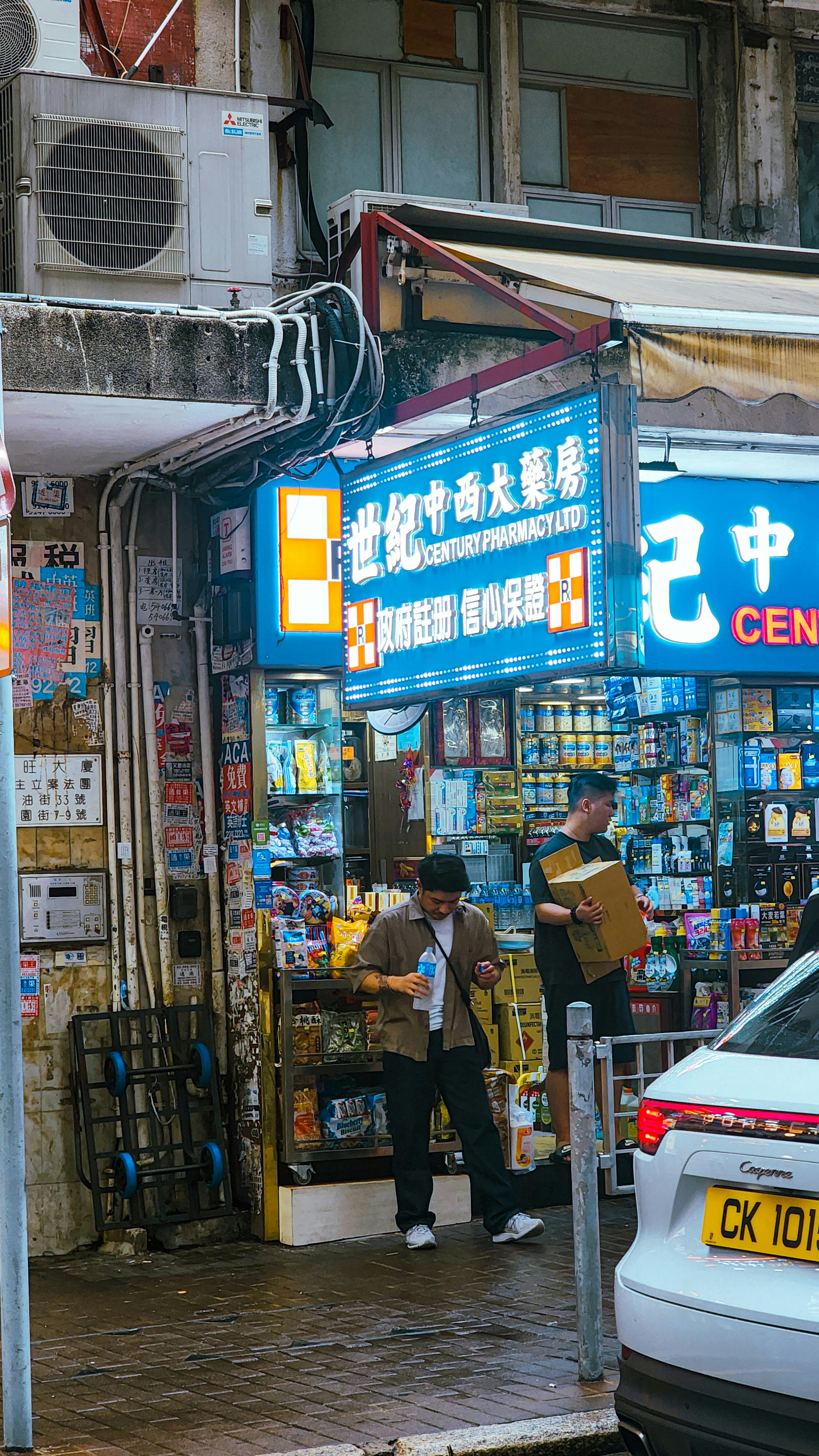 Neon Pharmacy Gatekeeper: A Busy Street Shopfront in Kowloon