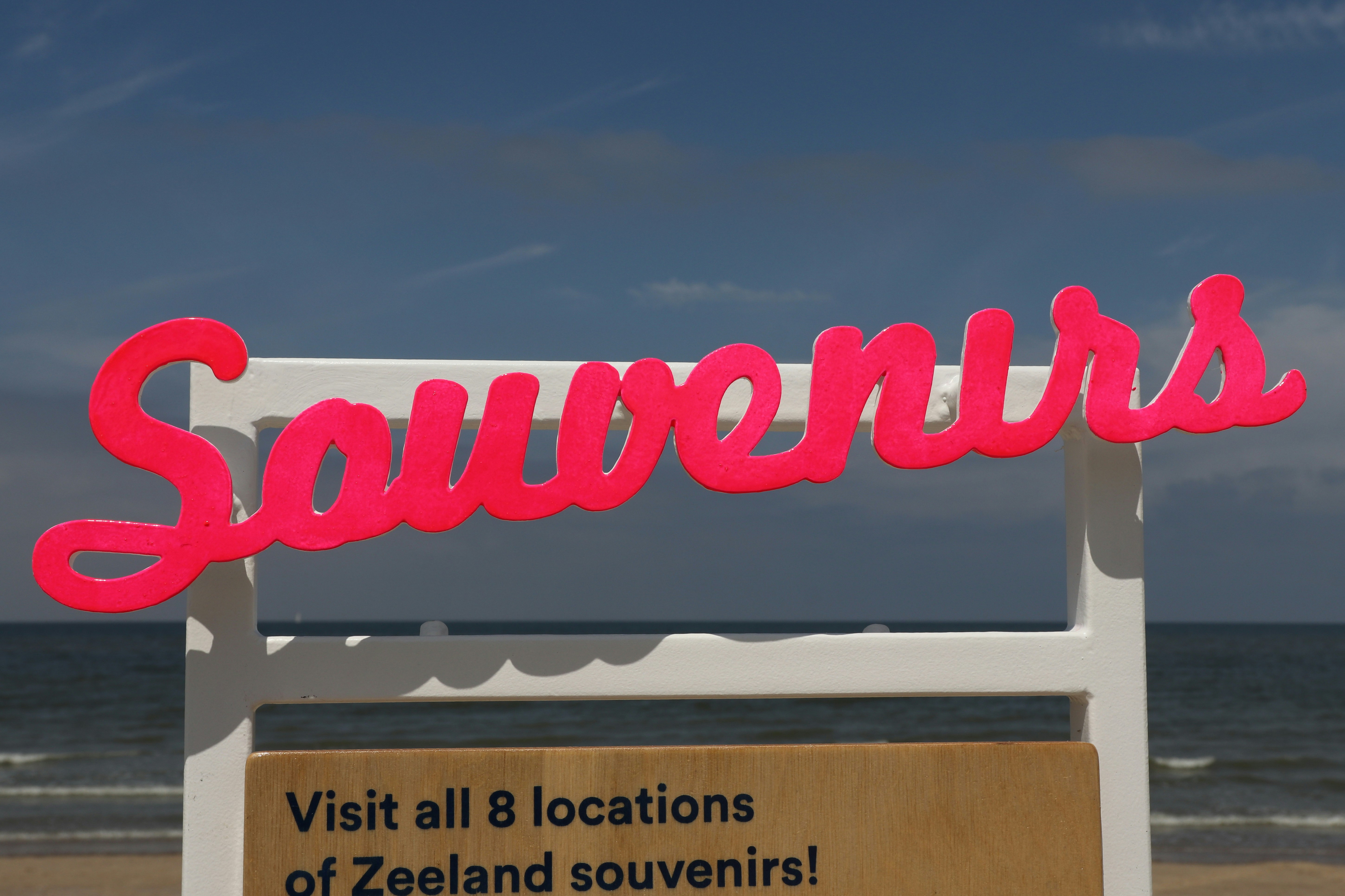 Saturated Red Signpost Over Beach Backdrop