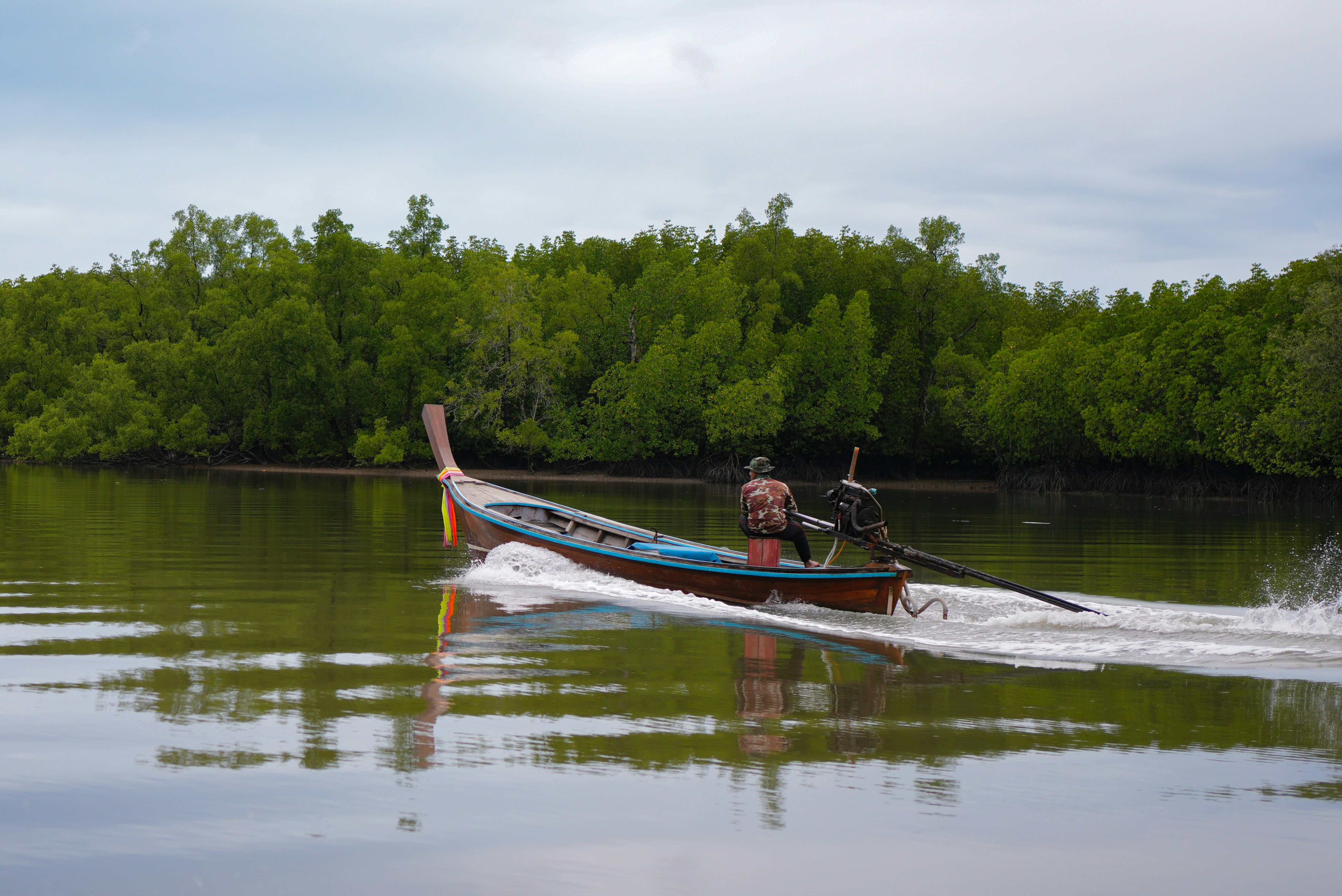 Riverbound Veteran: A Long-tail Boat Hums Across Quiet Waters