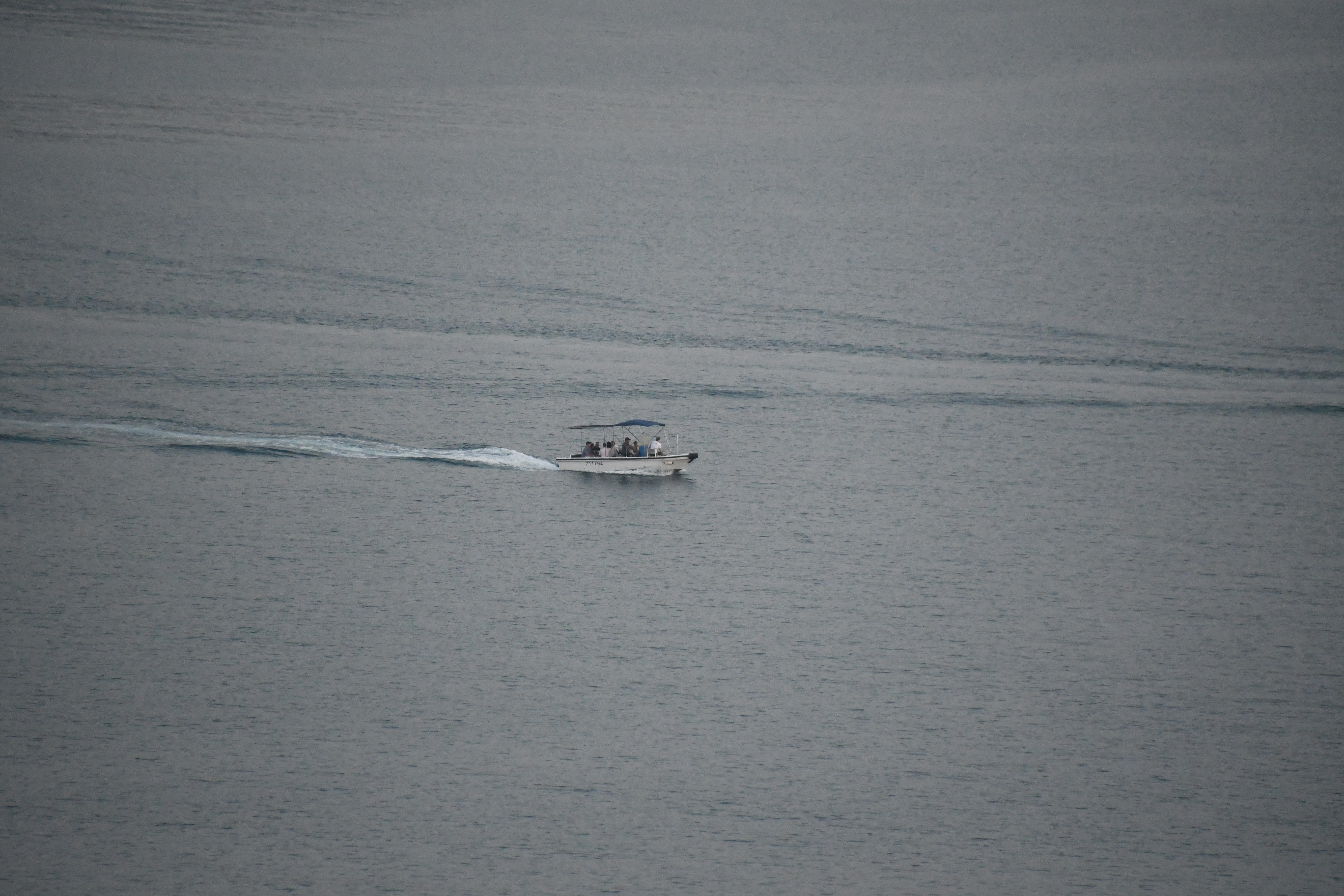 Isolated Boat Scudding Across a Calm Gray Sea
