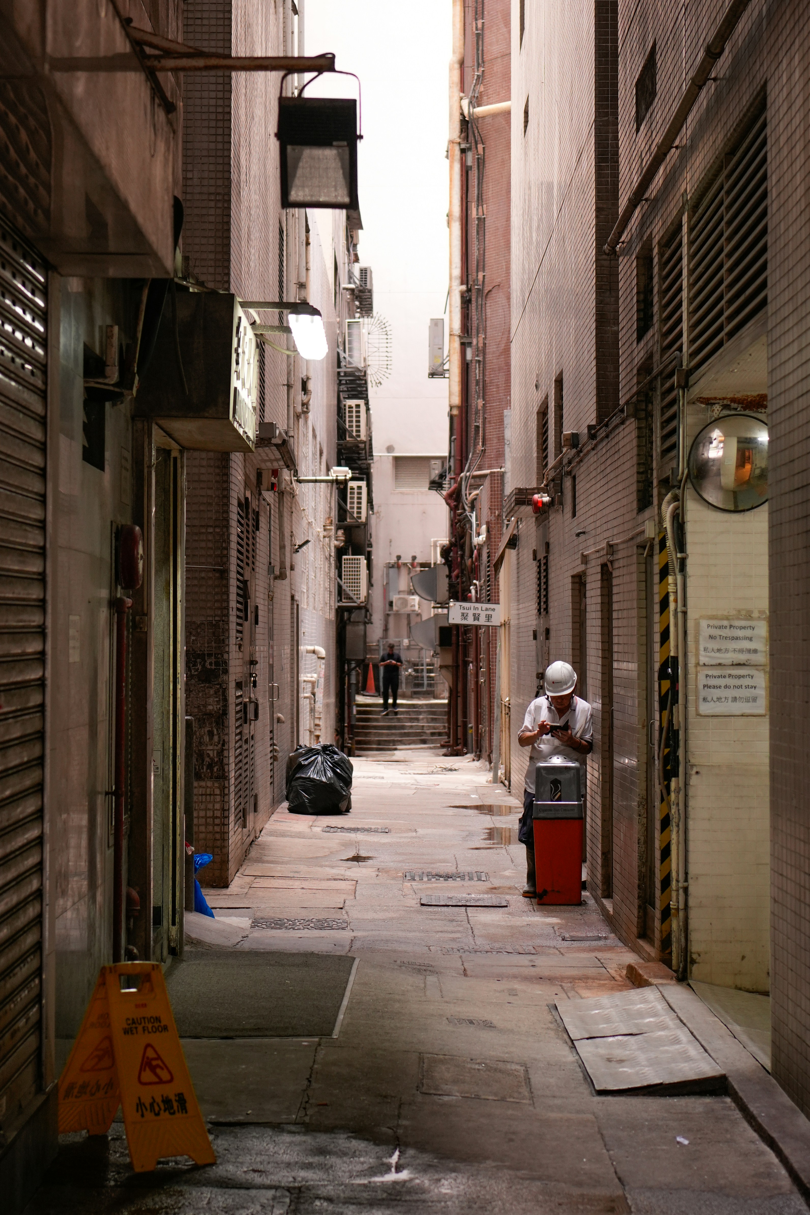 Narrow Alley Resolve: A Worker in a Quiet Backstreet