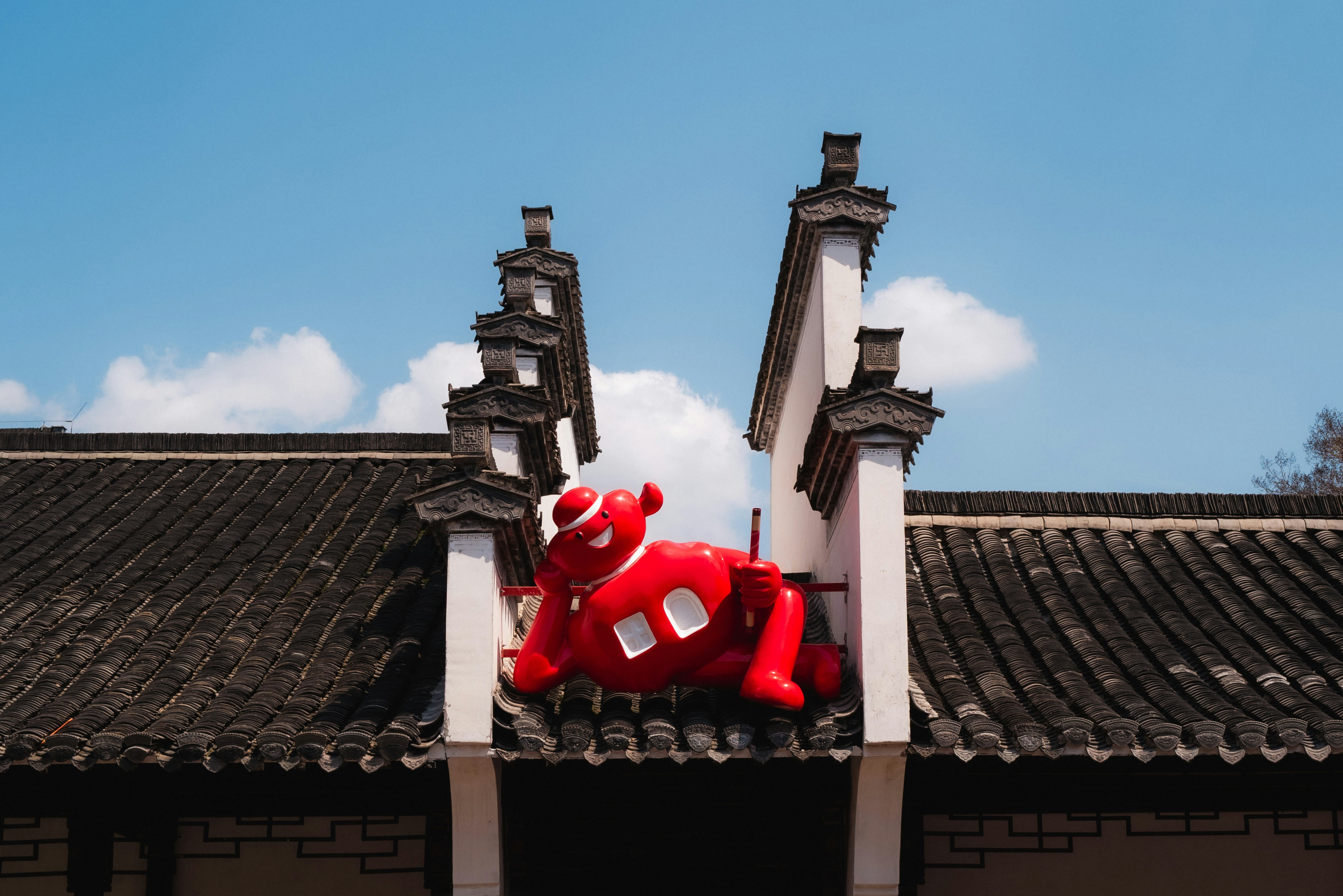 Red Recliner on the Roof: A Playful Doodle Amid Traditional Tiles