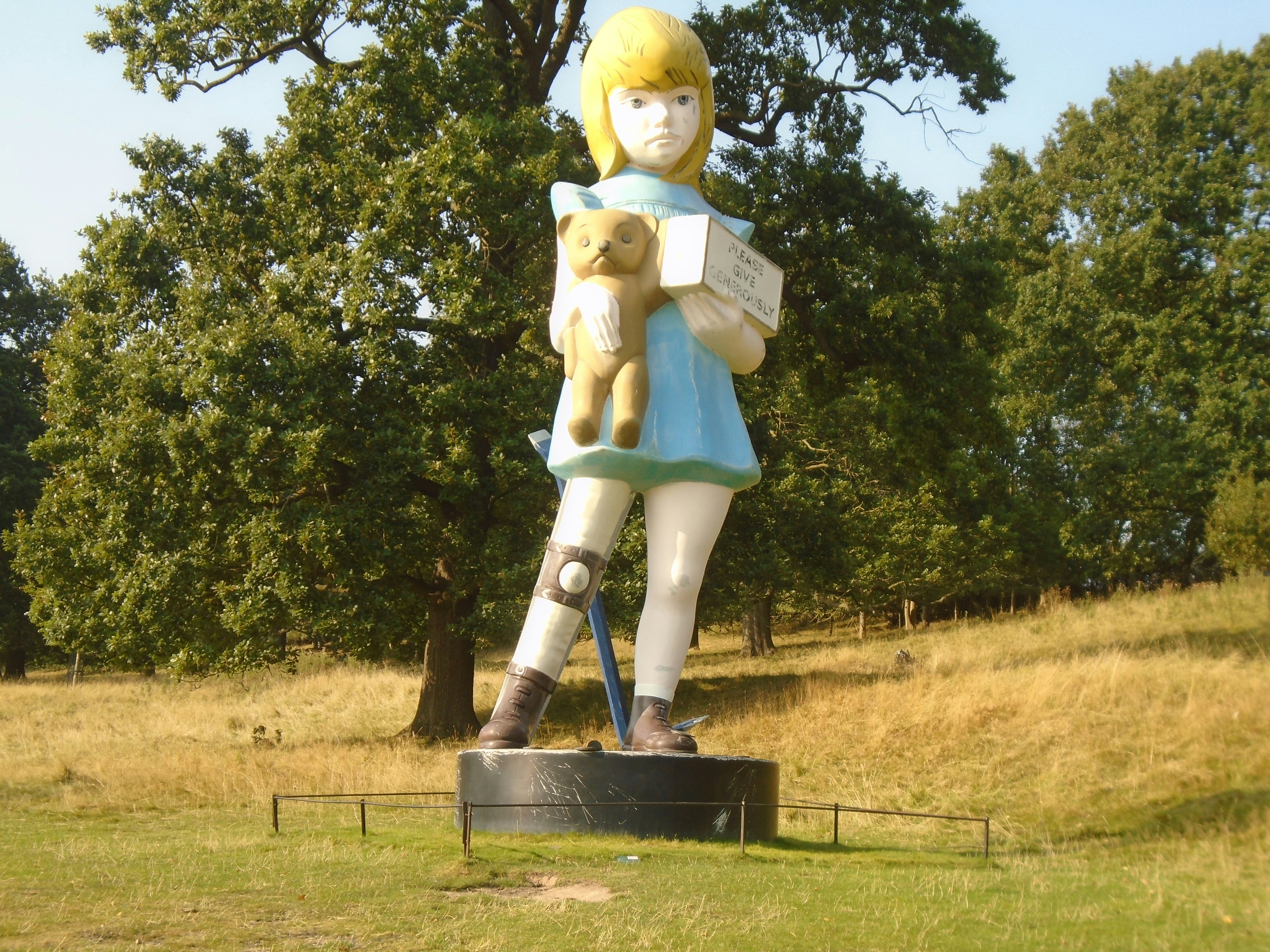 The Girl with a Book and Toy: A Statue Standalone in Sunlit Park