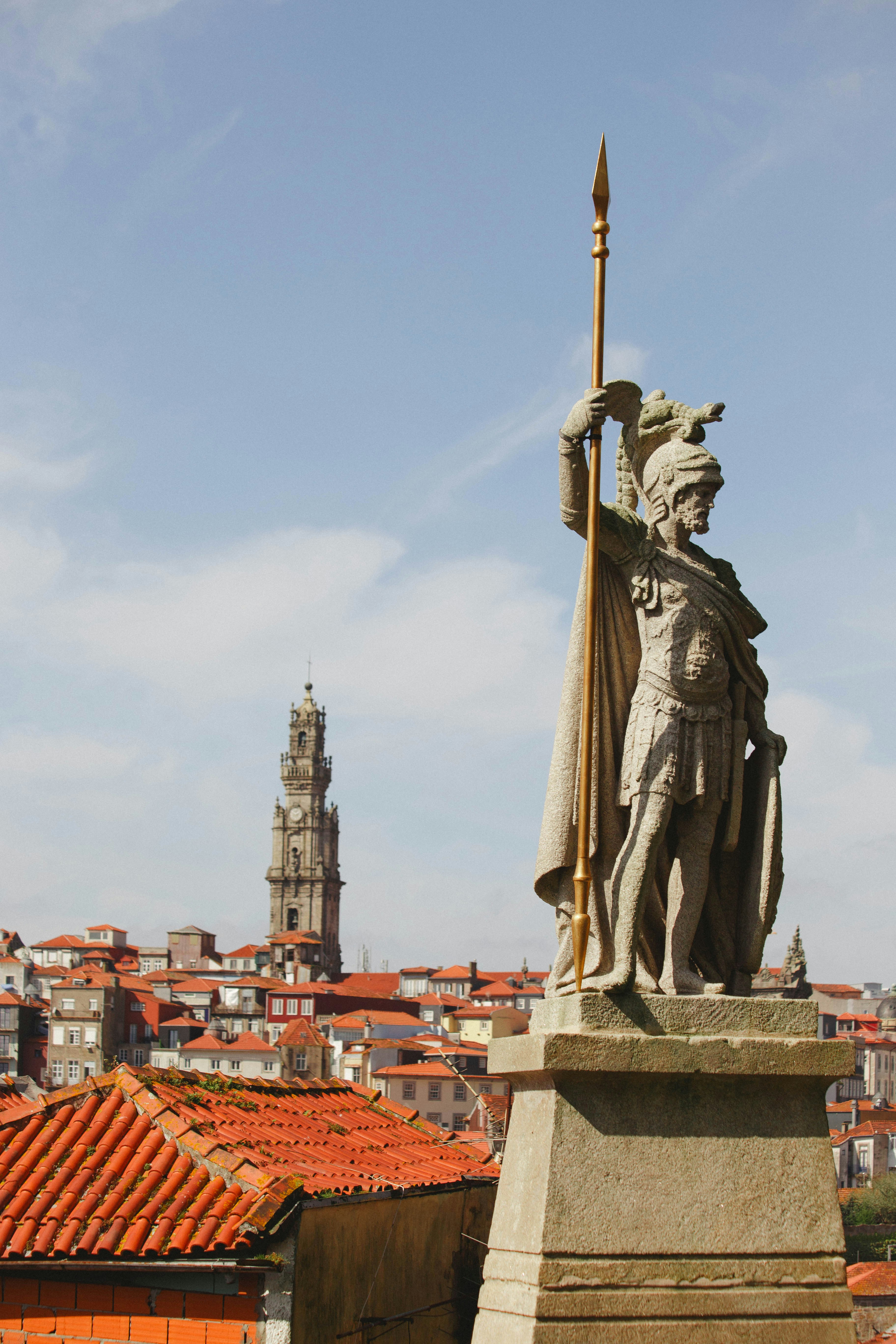 Sentry of the Red Tile City: A towering statue watching over terracotta roofs