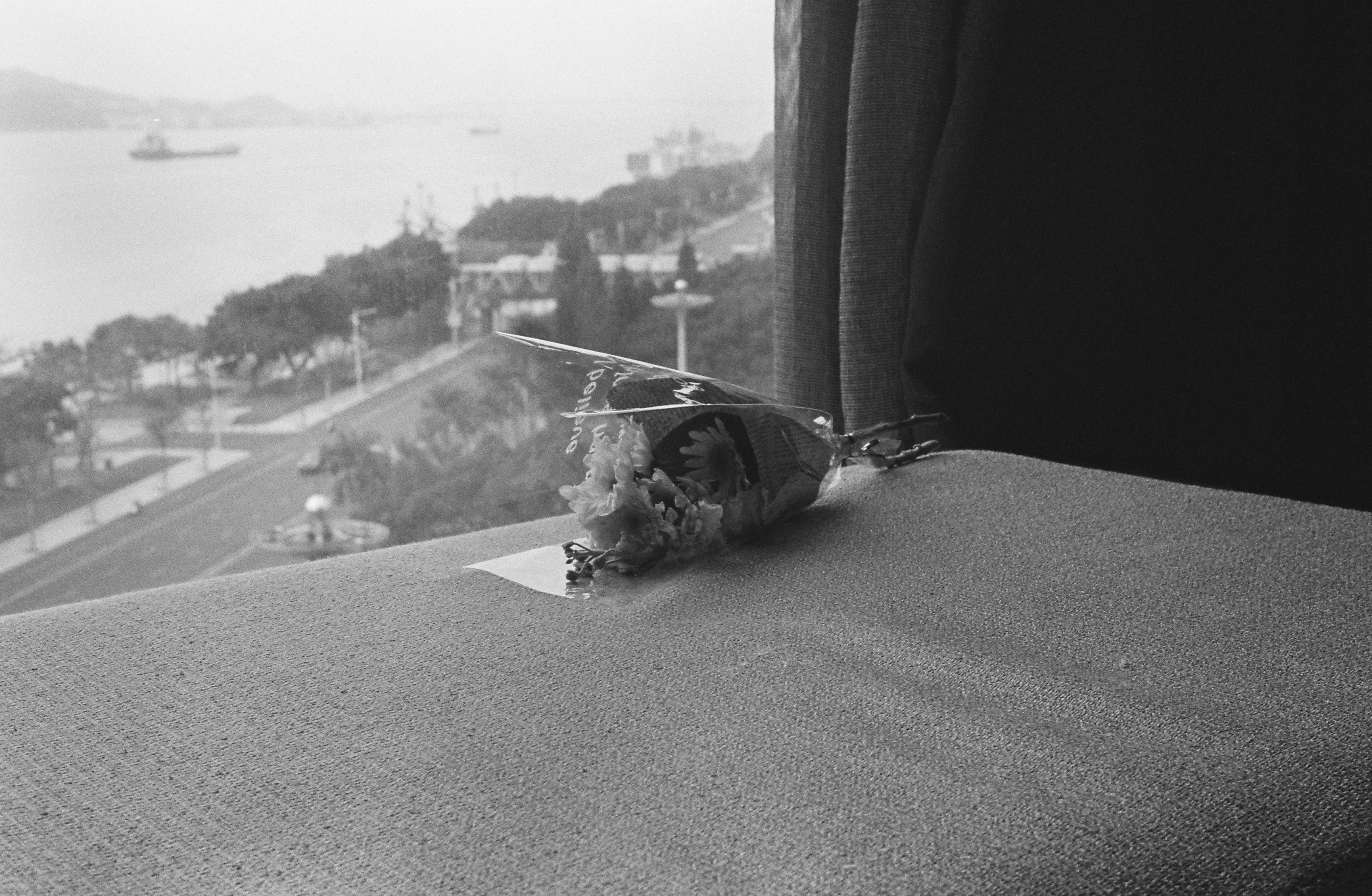 Desolate Balcony: A Cigarette Butts and Crumbling Edge over a Distant Harbor
