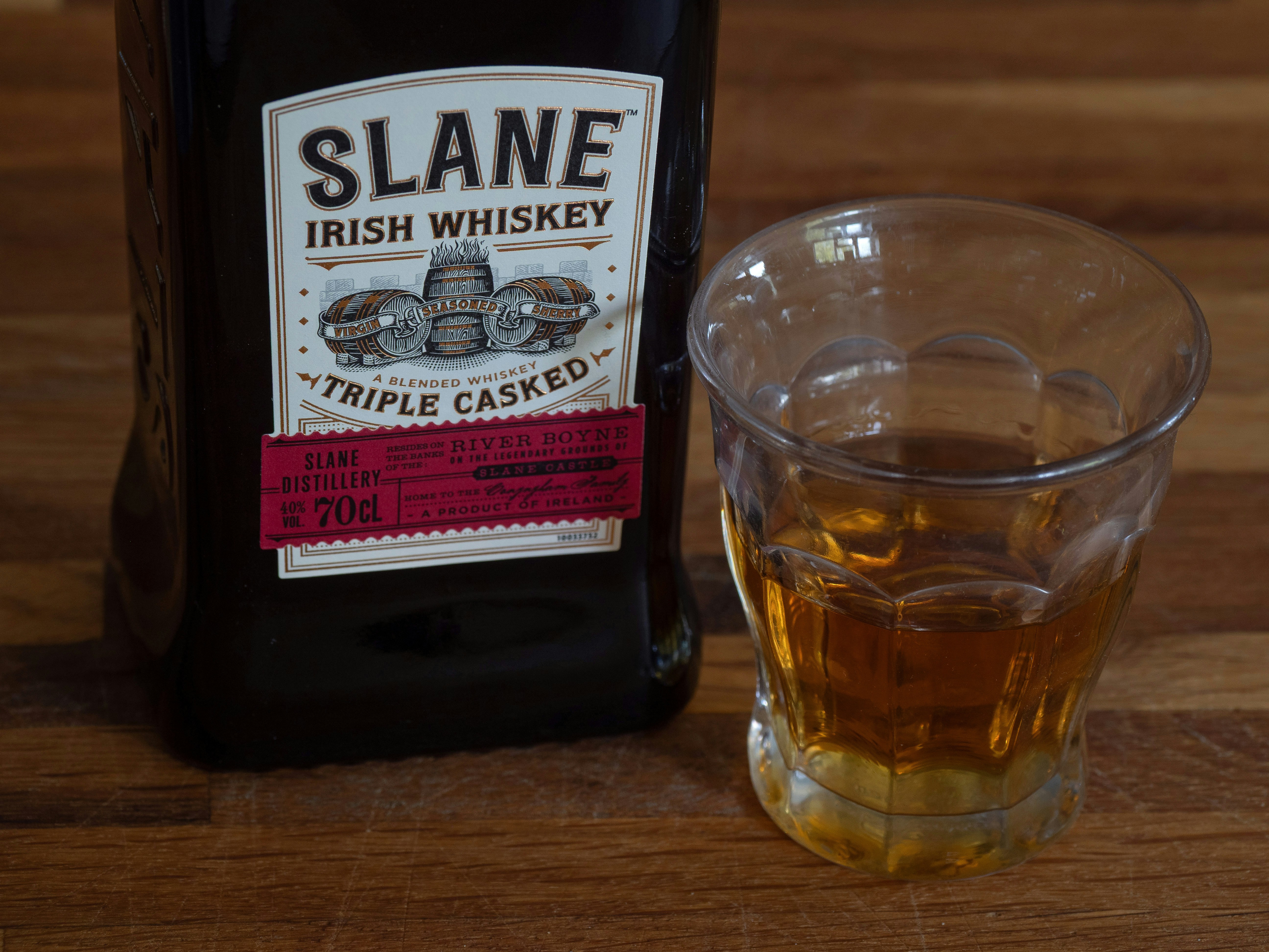 Whiskey on Wood: Slane Bottle and Glass in Quiet Studio