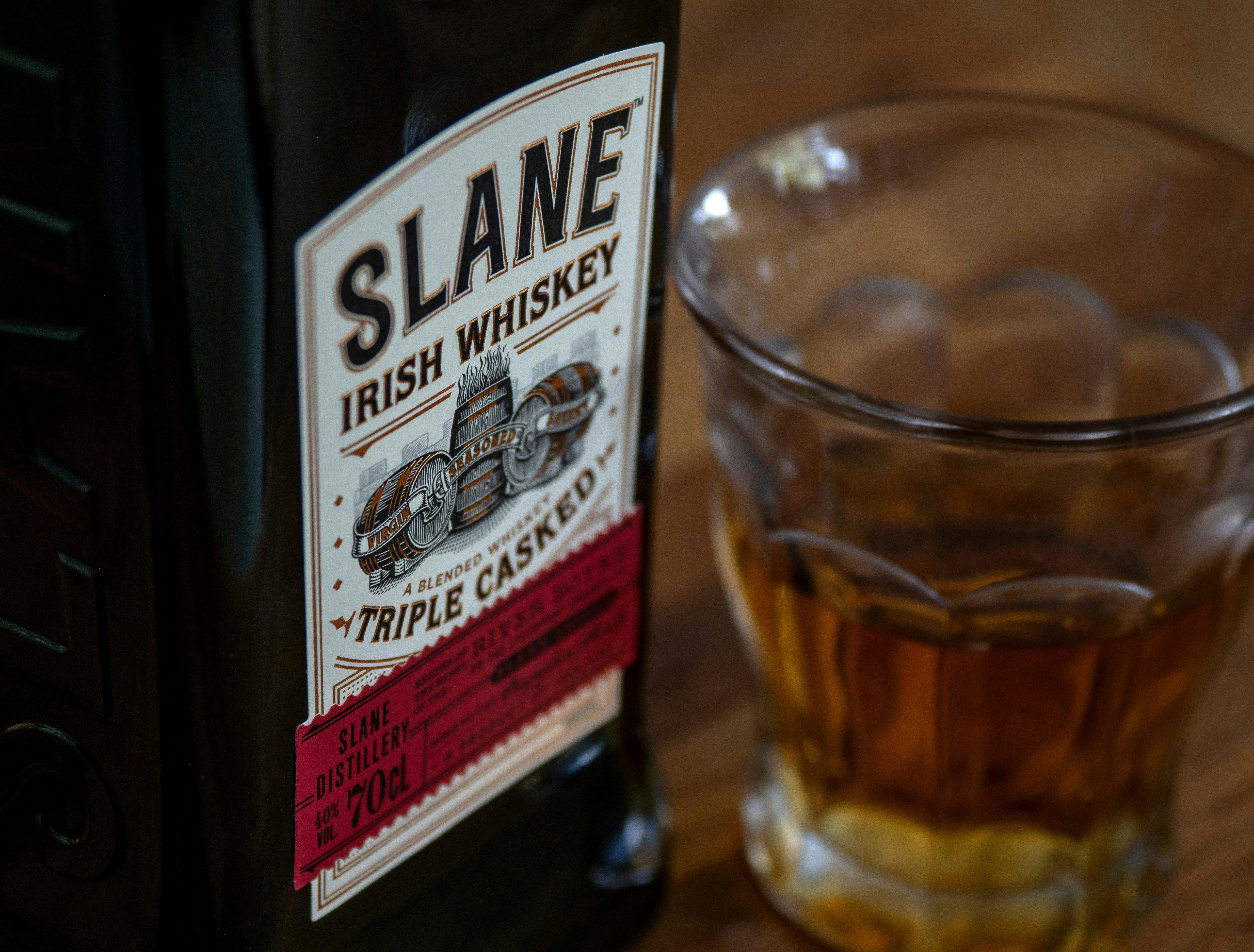 Slane Irish Whiskey Label with Glass on a Wooden Bar