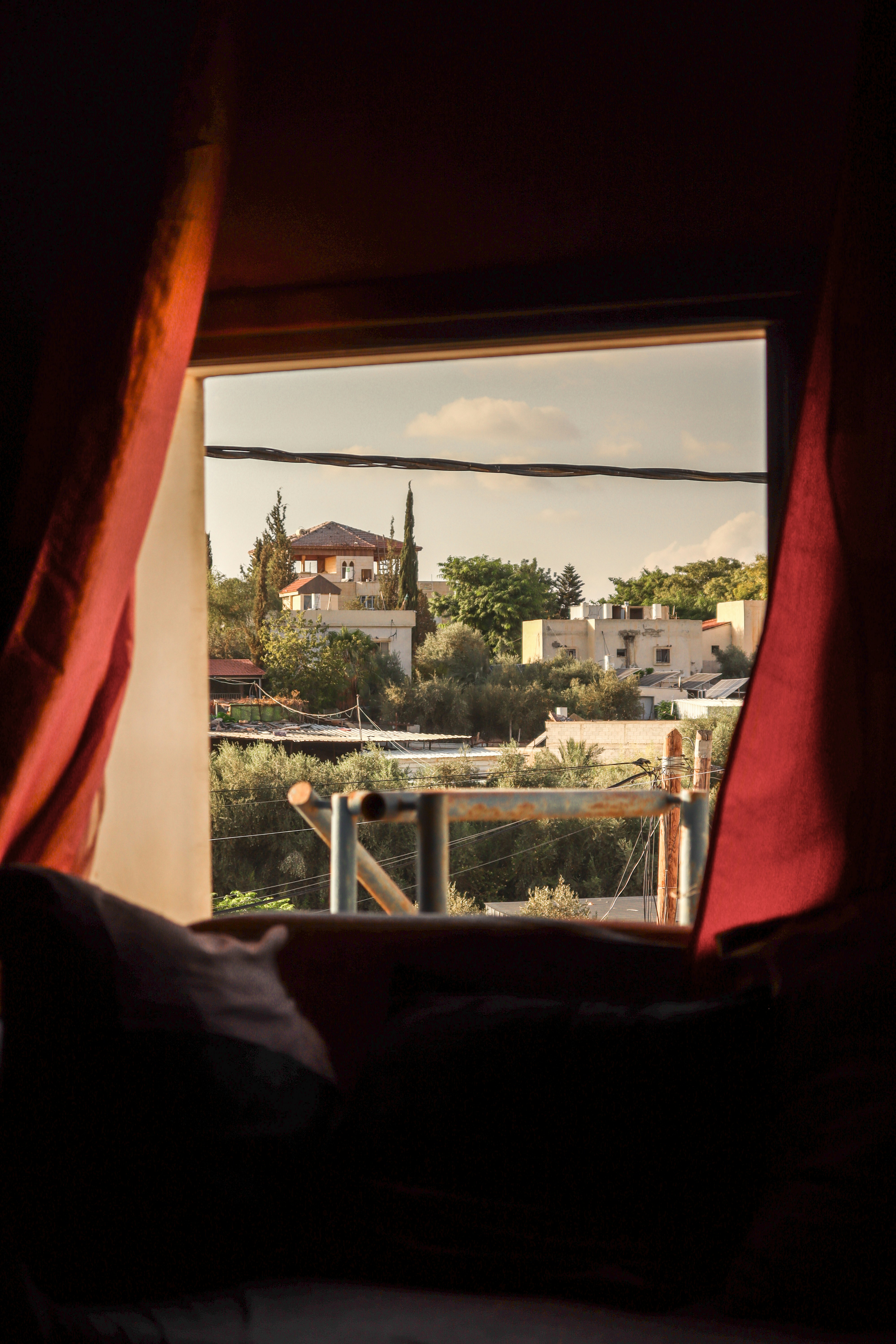Window to a Quiet Town: Neighborhood Dwellings Framed by Red Curtains