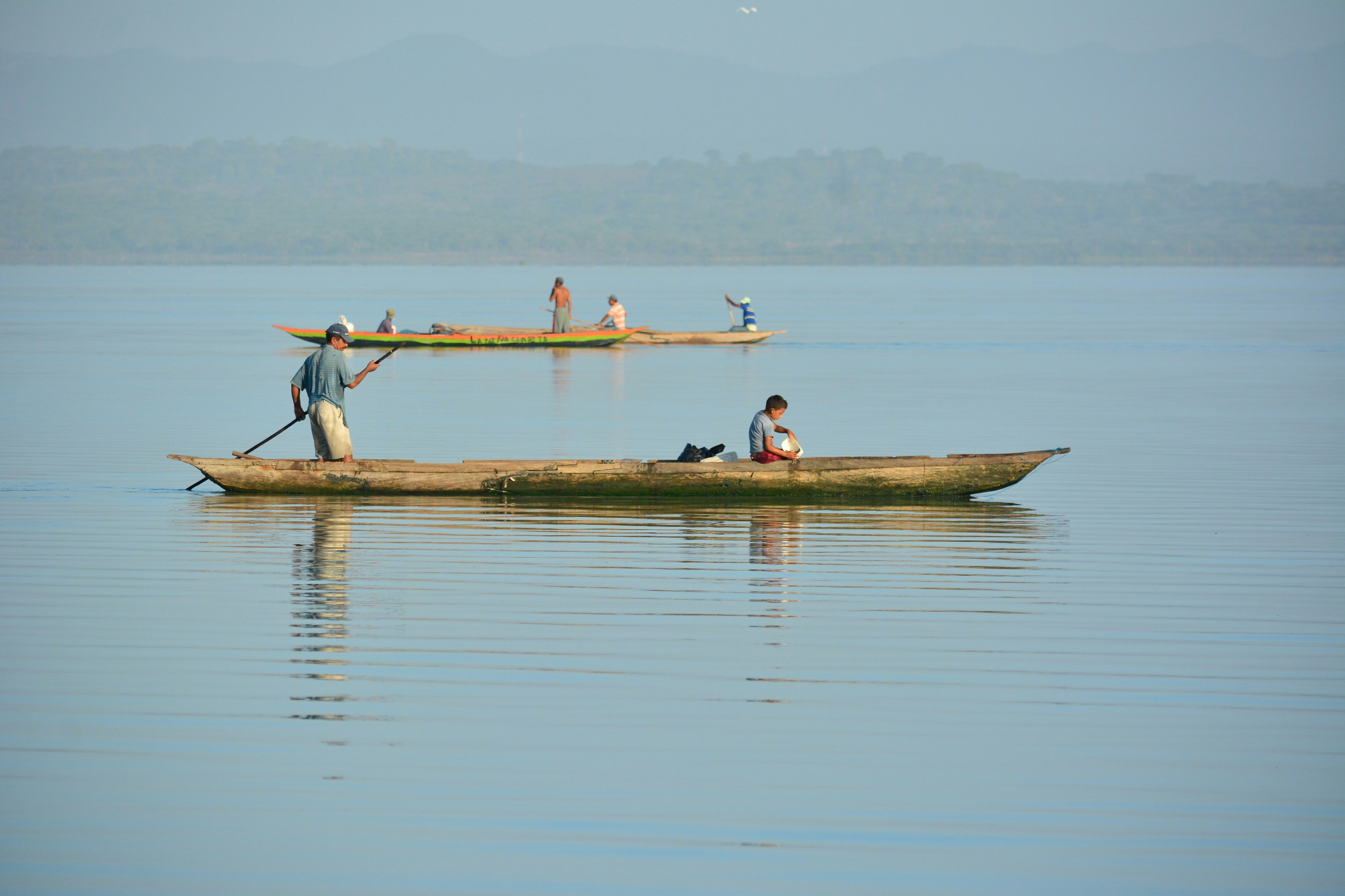 Calm Convoy: Narrow Boats Drift Across a Silvery Lake