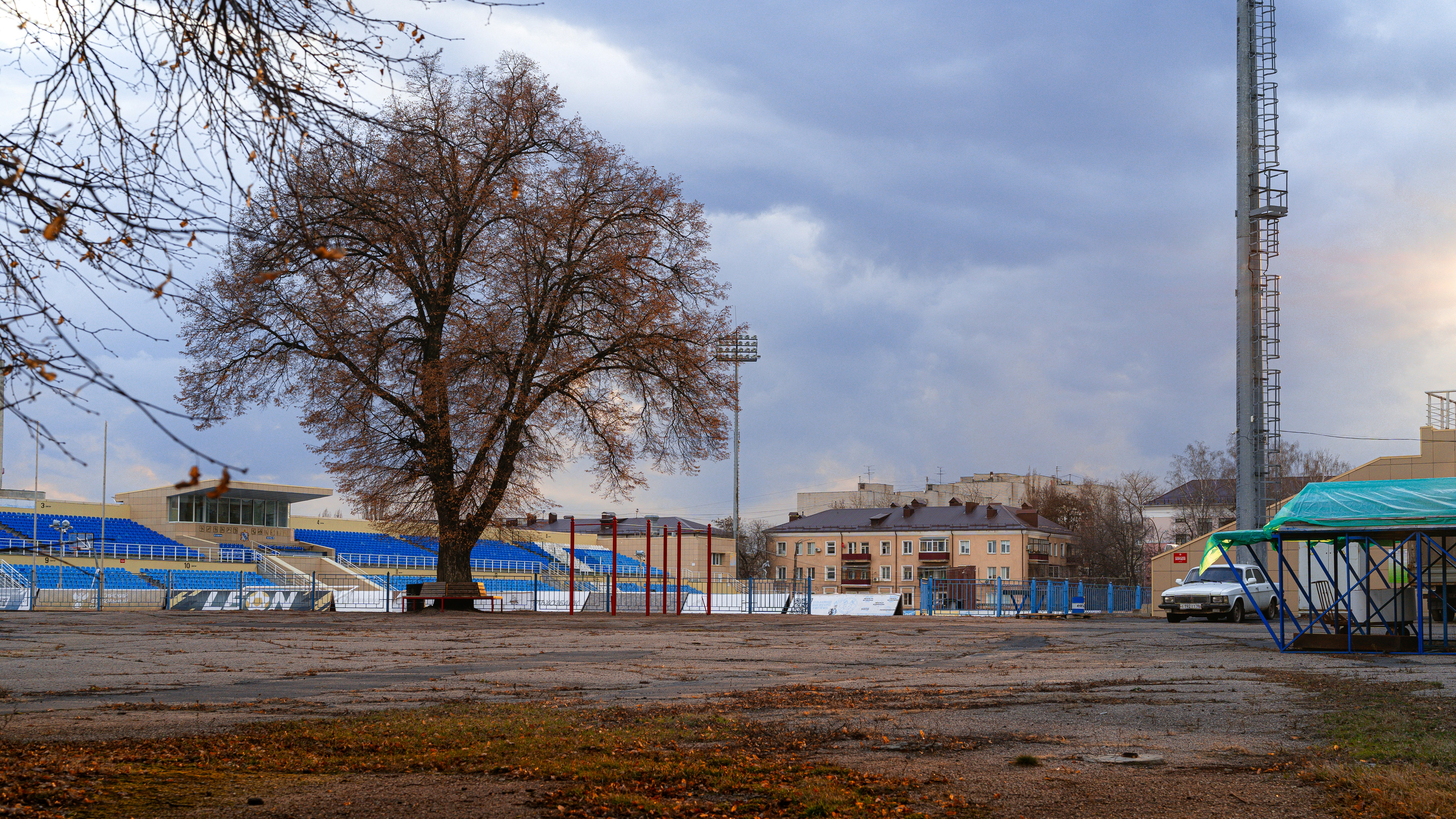 Deserted Field by the Distant Stadium Under a Quiet Sky