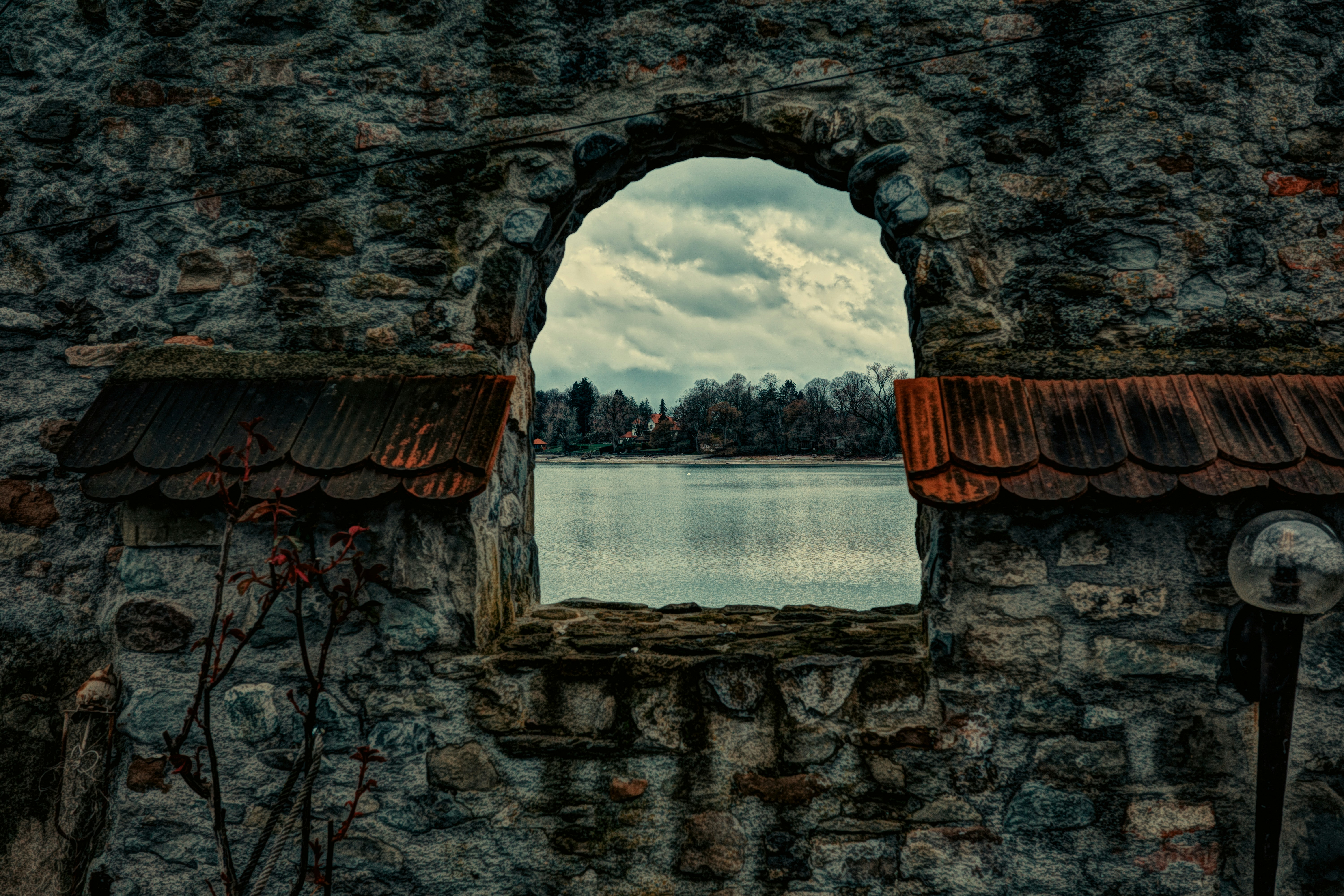 Window to the lake: an ancient stone frame peering at calm waters