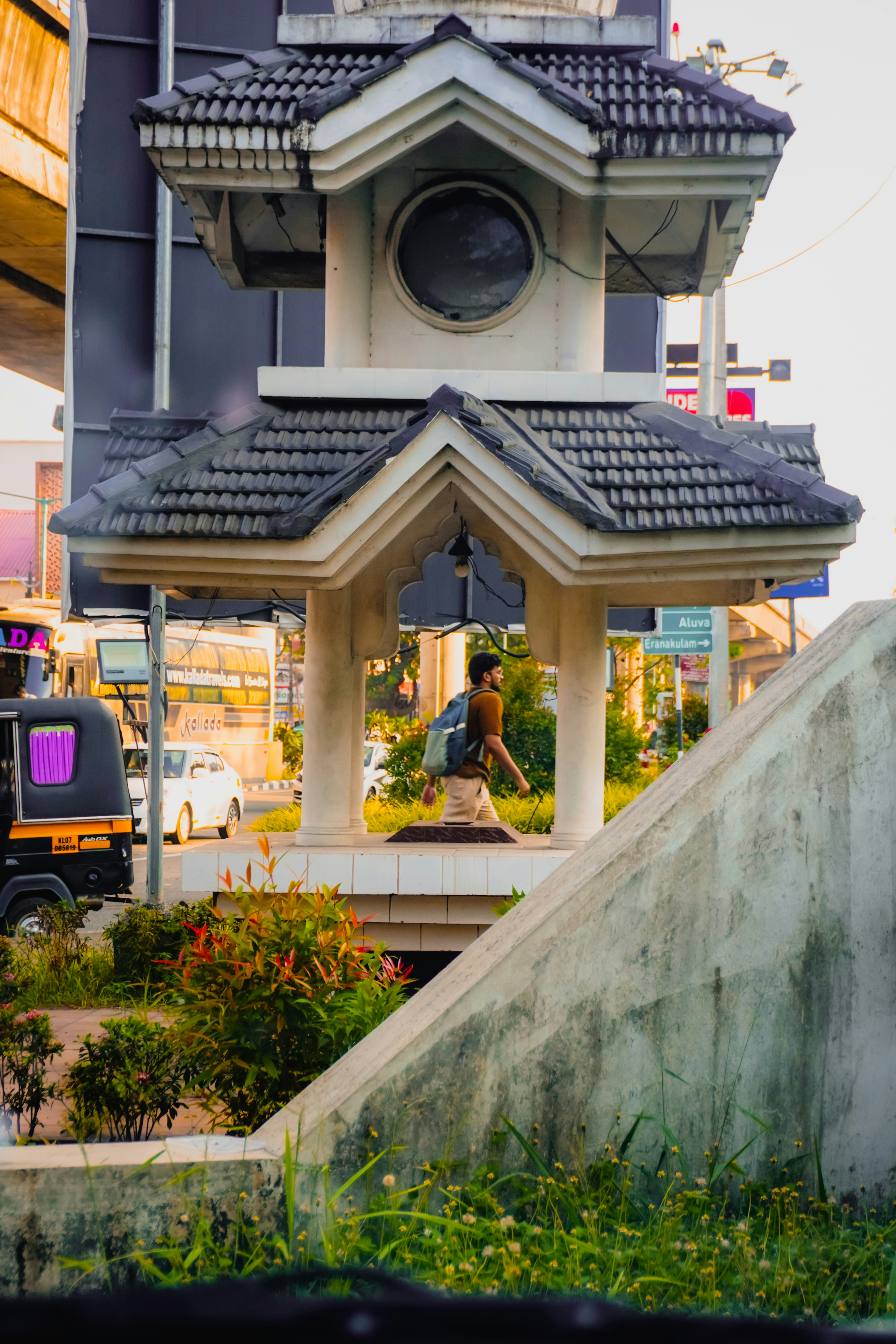 Urban Shrine: A Pedestrian Passes Beneath a Quiet Pagoda in Motion