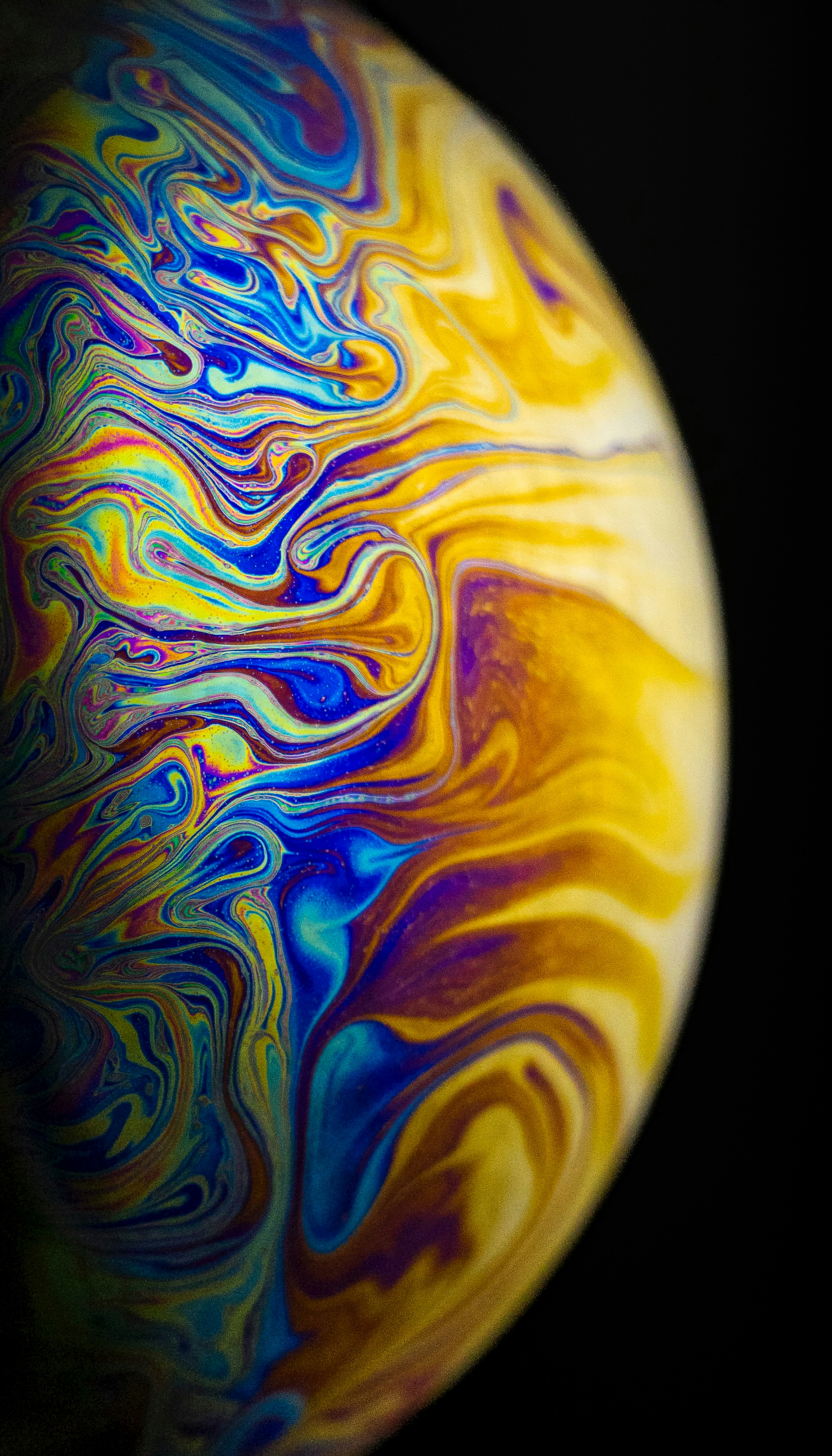 Colorful Swirl Portrait: A Macro Bubble Planet Against Black