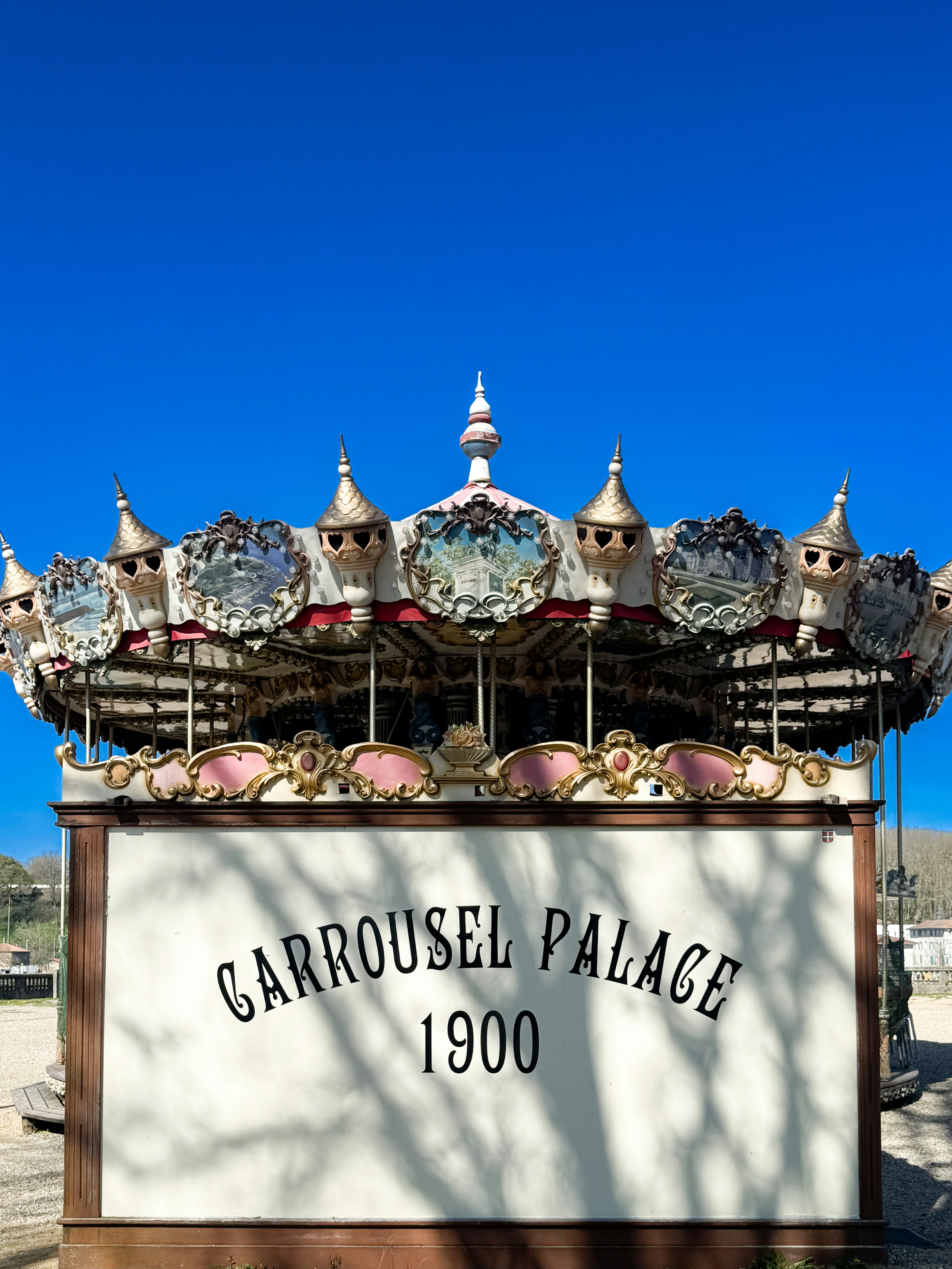 Carousel Palace Sign: A Quiet Moment Under the Spinning Carved Roof