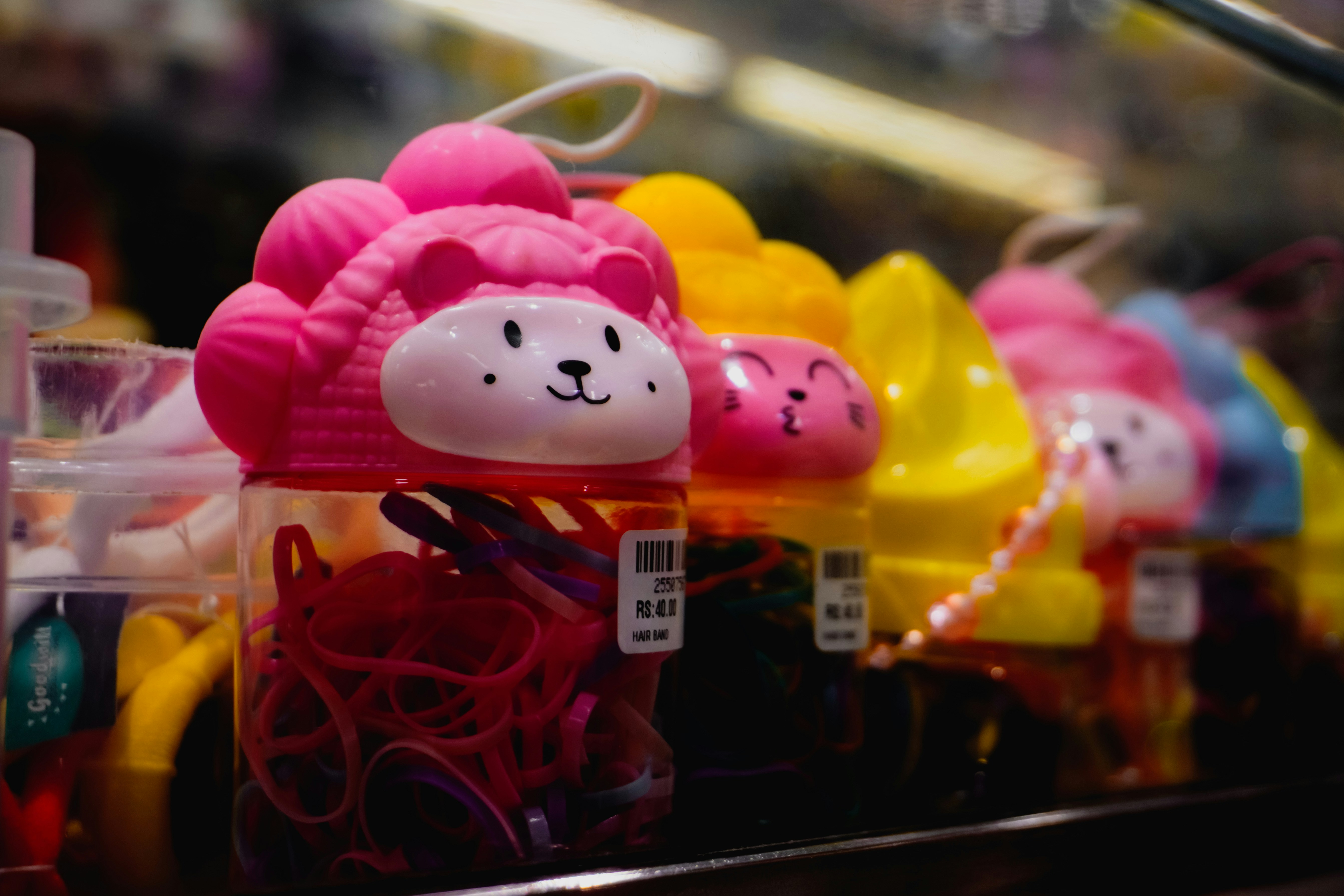 Kawaii Gumball Carriers: Row of Pink Plush Rabbits in a Trance of Colorful Toys