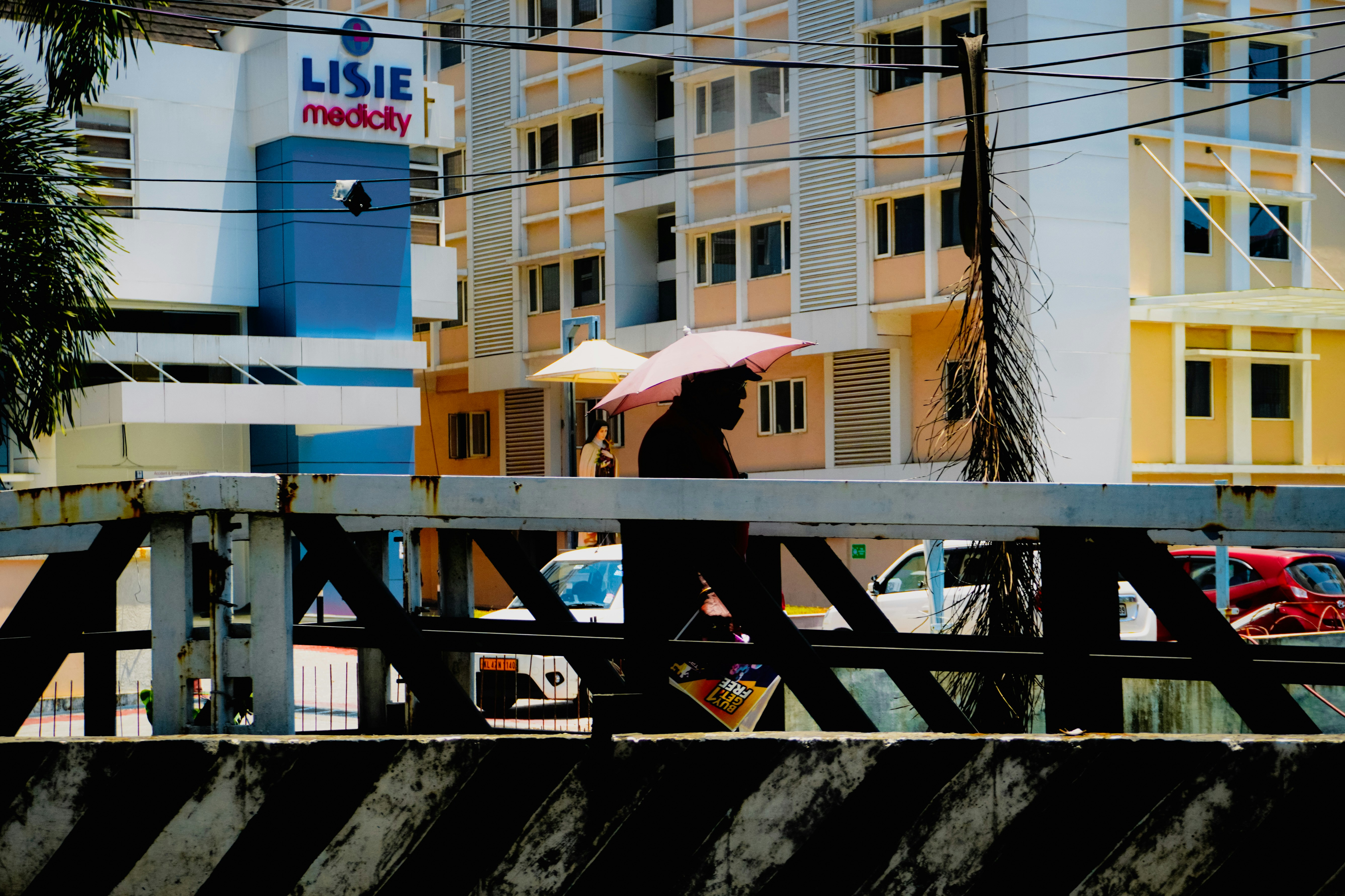 Umbrella atop the pedestrian path against a sunlit apartment block