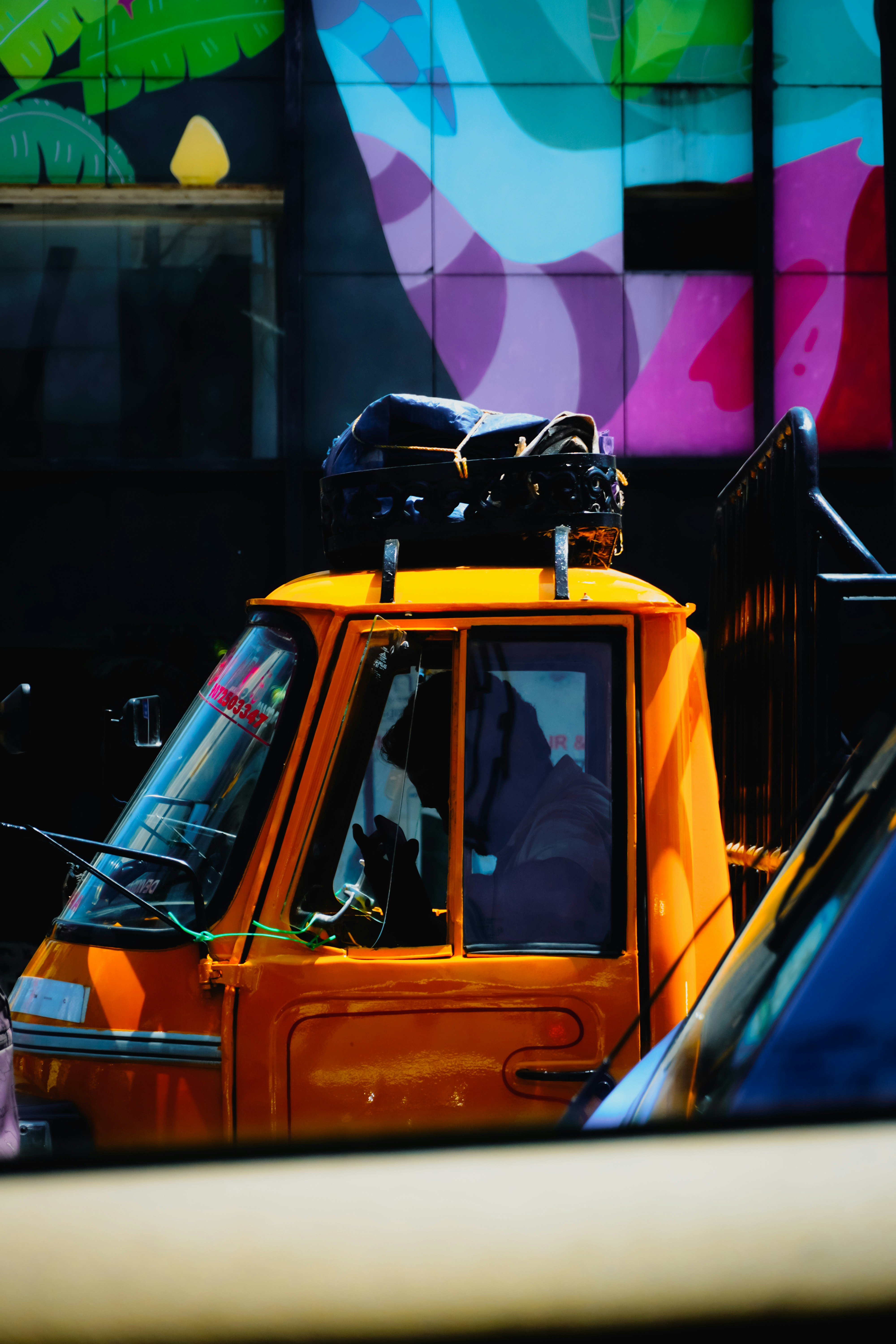 Orange cab in front of a mural: a vivid urban study in color and contrast