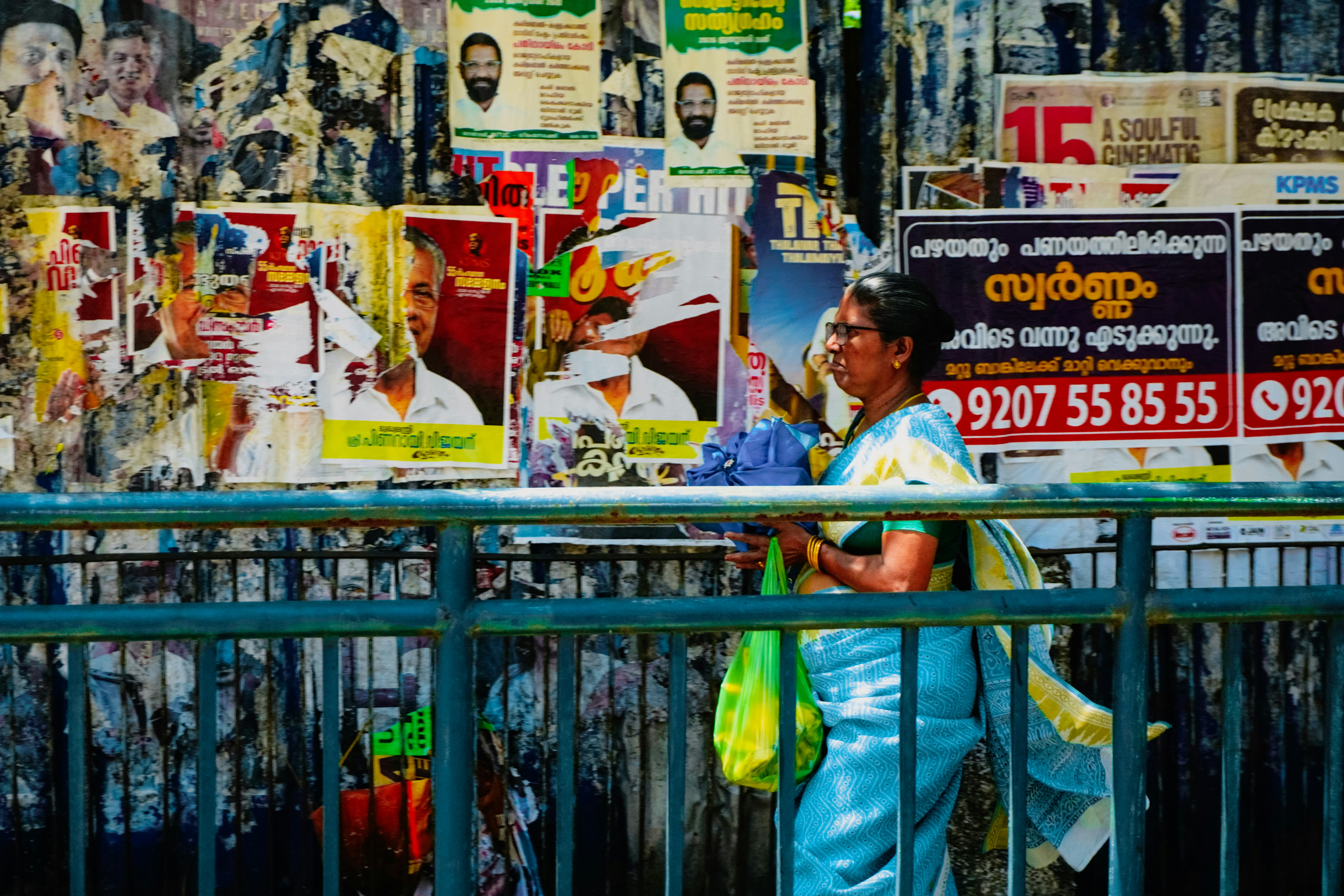 She Walks the Posters: A Moment Along the Wall of Advertisements
